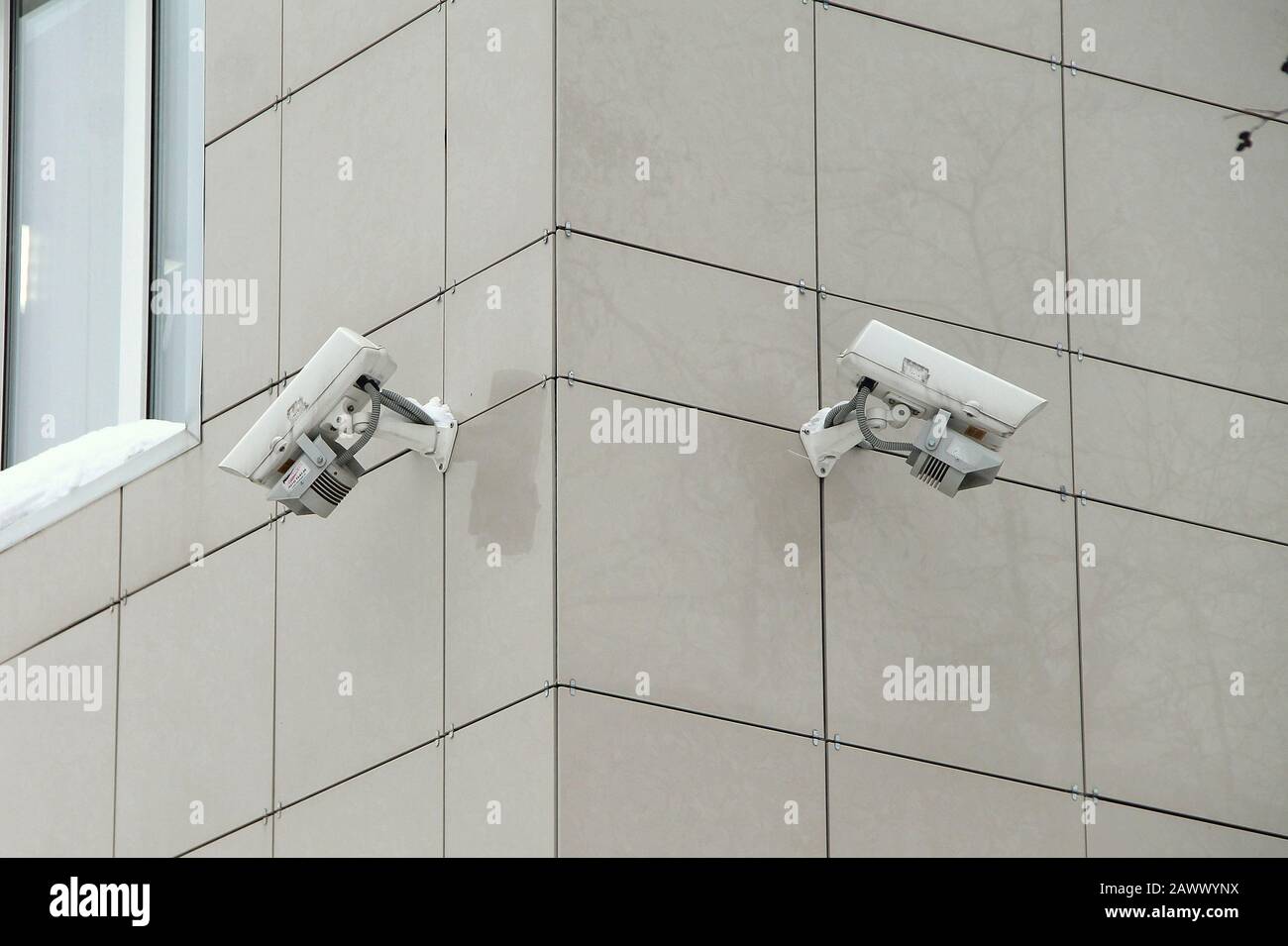 Surveillance camera mounted on tiled wall of house. Security concept ...
