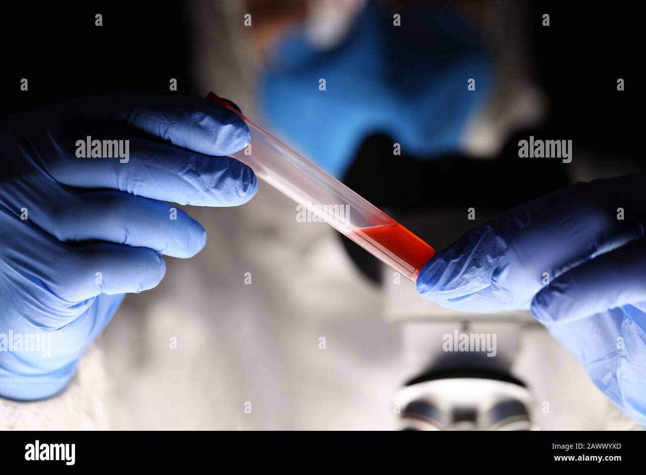 Male chemist examining blood sample in dark laboratory Stock Photo - Alamy