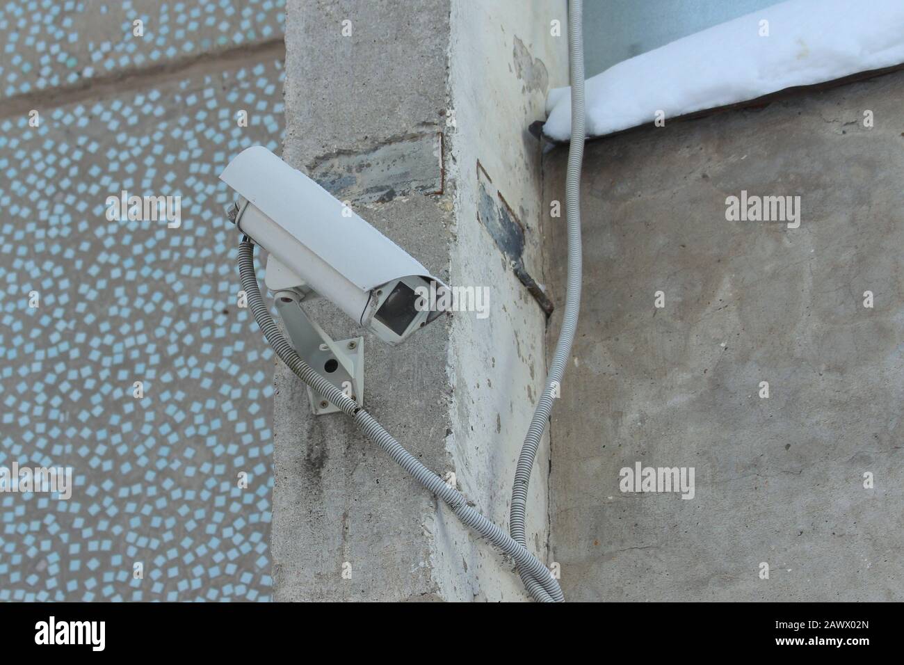 Surveillance camera mounted on tiled wall of house. Security concept ...