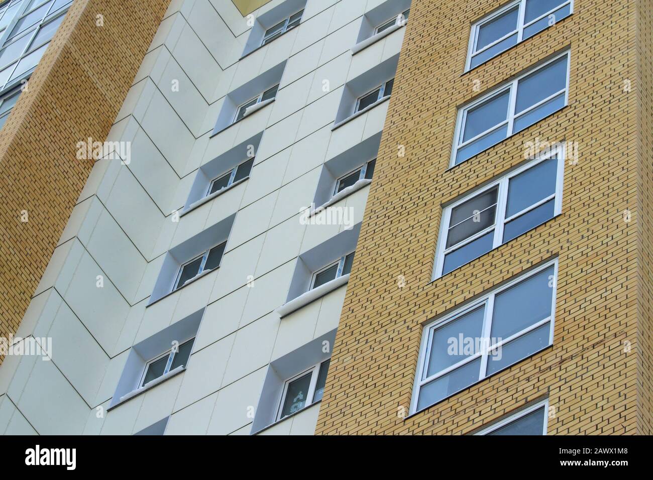 Plastic windows in a modern tiled brick high-rise house. Bottom view ...