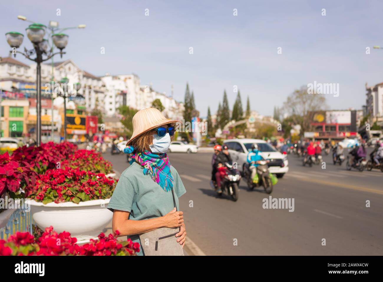 Caucasian woman wearing sanitary mask outdoors in Da Lat city centre ...