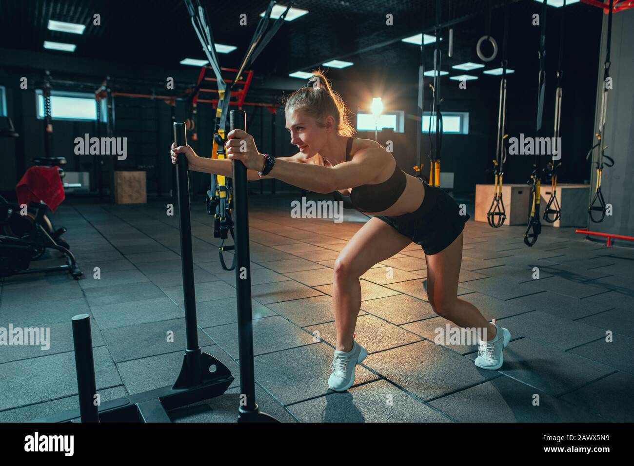 Energy. Young muscular caucasian woman practicing in gym with the ...
