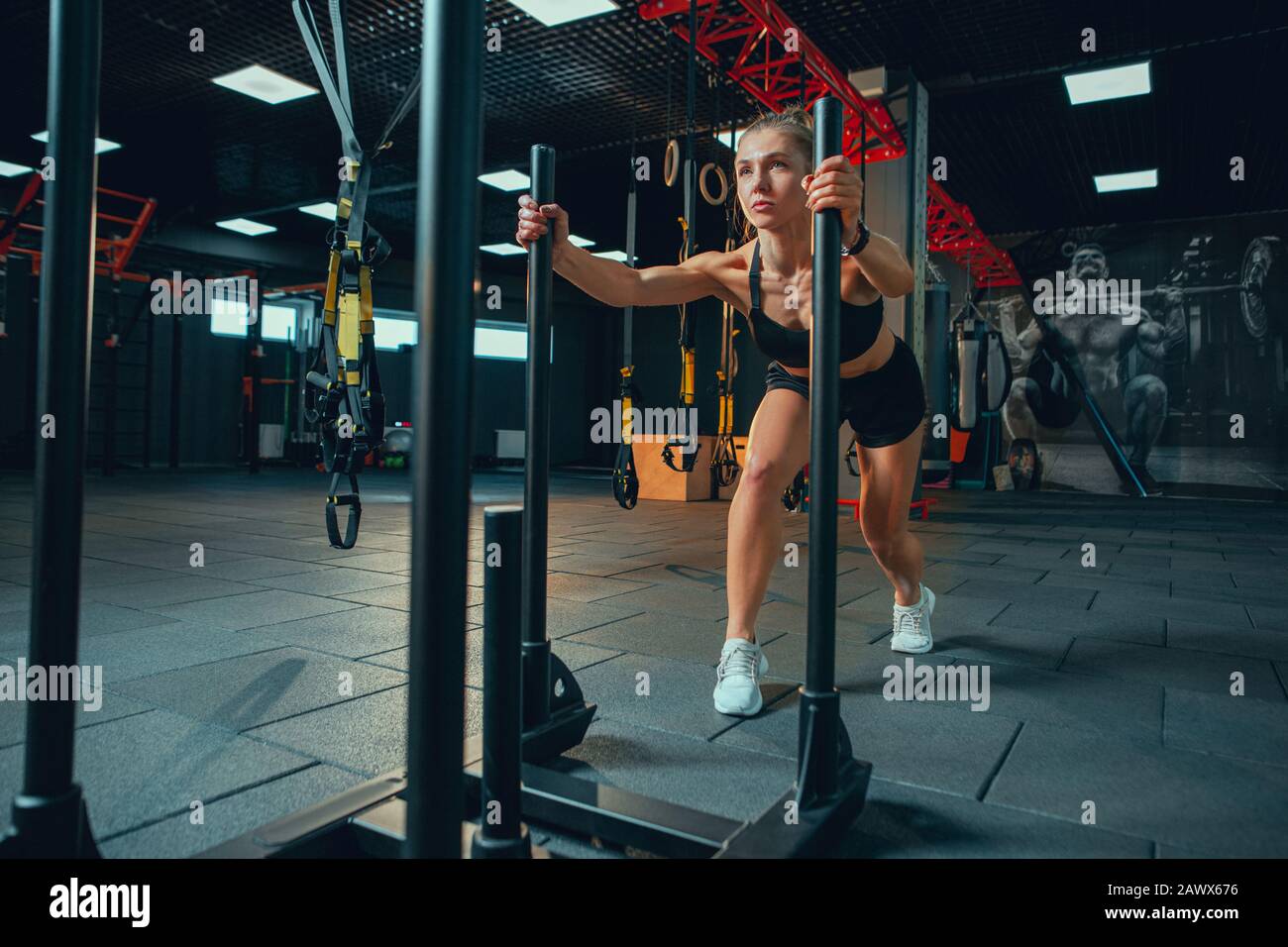 Energy. Young muscular caucasian woman practicing in gym with the ...