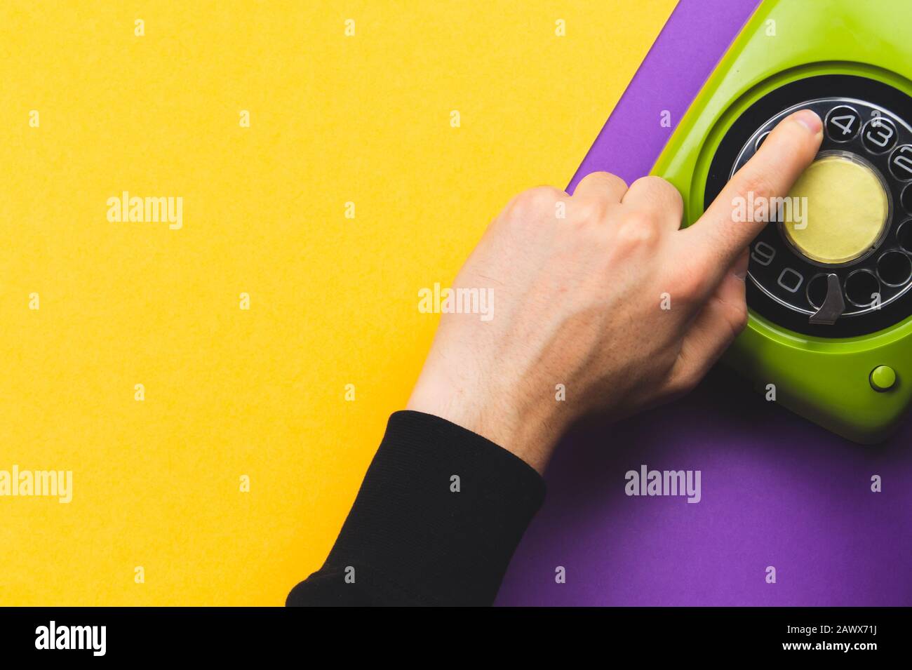 Hand dialing a number on a classic phone with round dial. vintage green ...