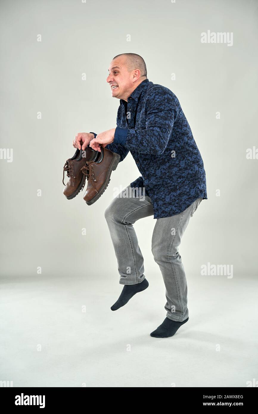 Man holding his shoes and walking tiptoe in complete silence Stock ...