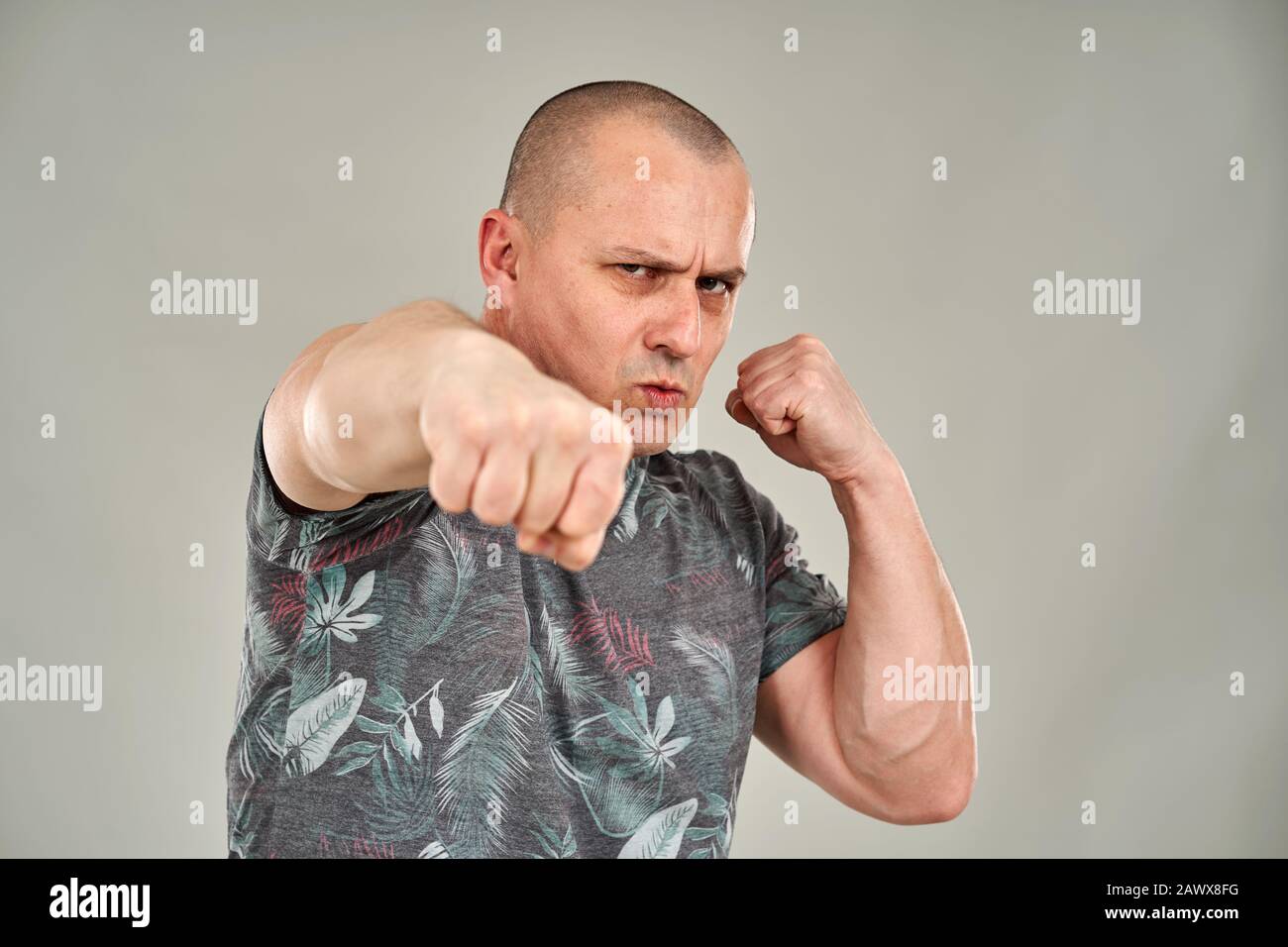Strong built angry man punching towards the camera Stock Photo - Alamy