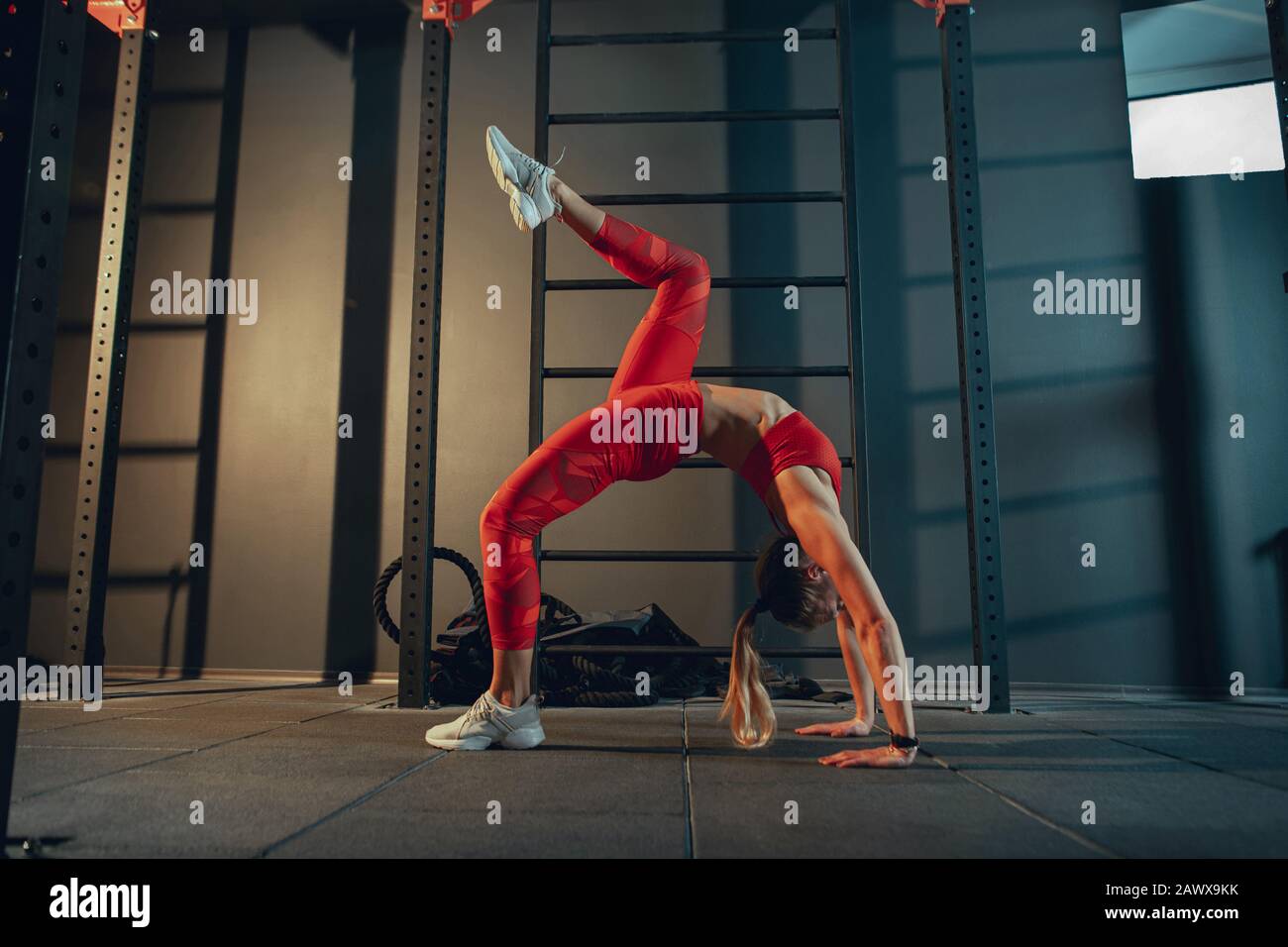 Graceful. Young muscular caucasian woman practicing in gym. Athletic ...