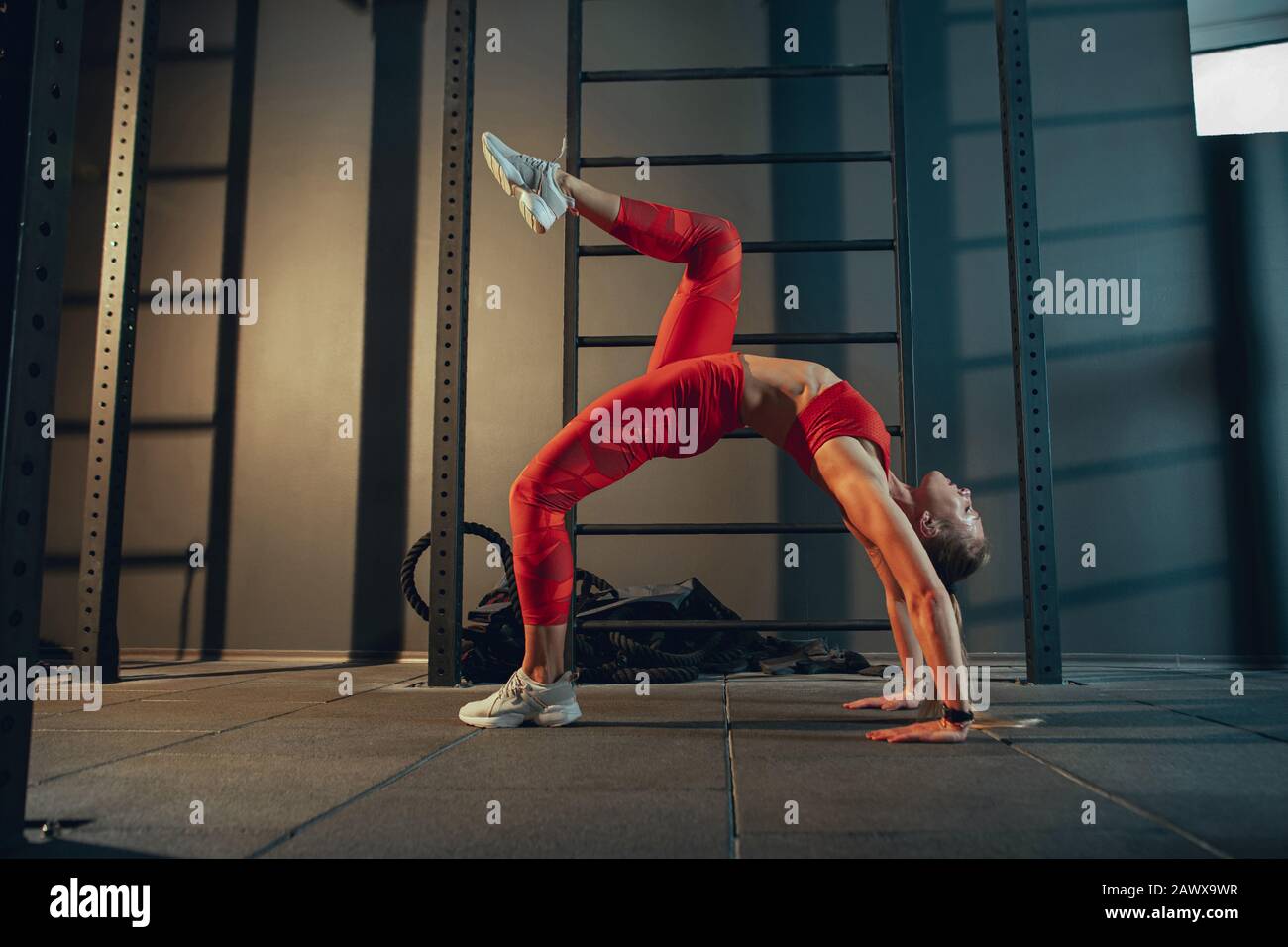 Graceful. Young muscular caucasian woman practicing in gym. Athletic ...