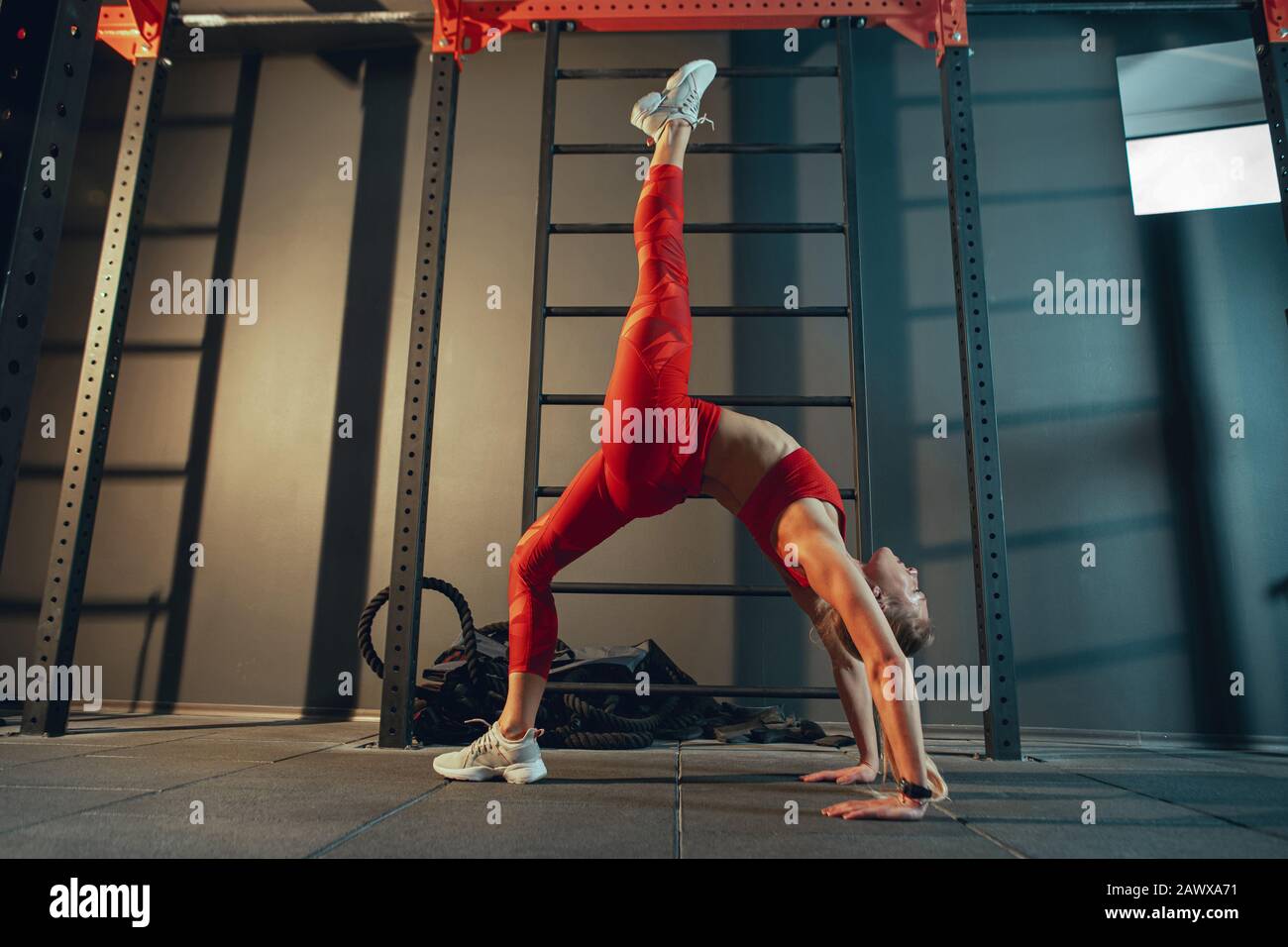 Graceful. Young muscular caucasian woman practicing in gym. Athletic ...