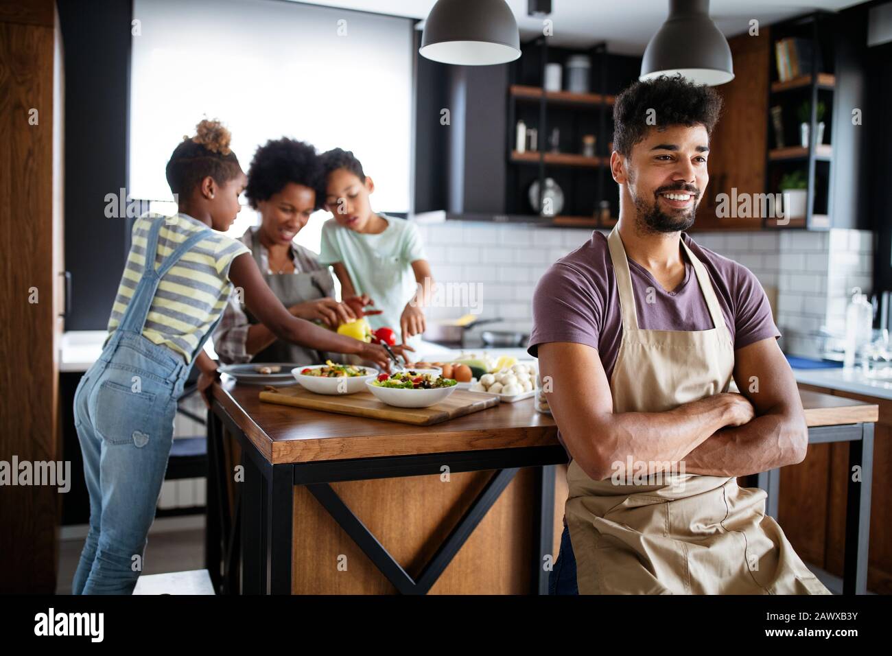 Happy family cooking together food in the kitchen Stock Photo - Alamy