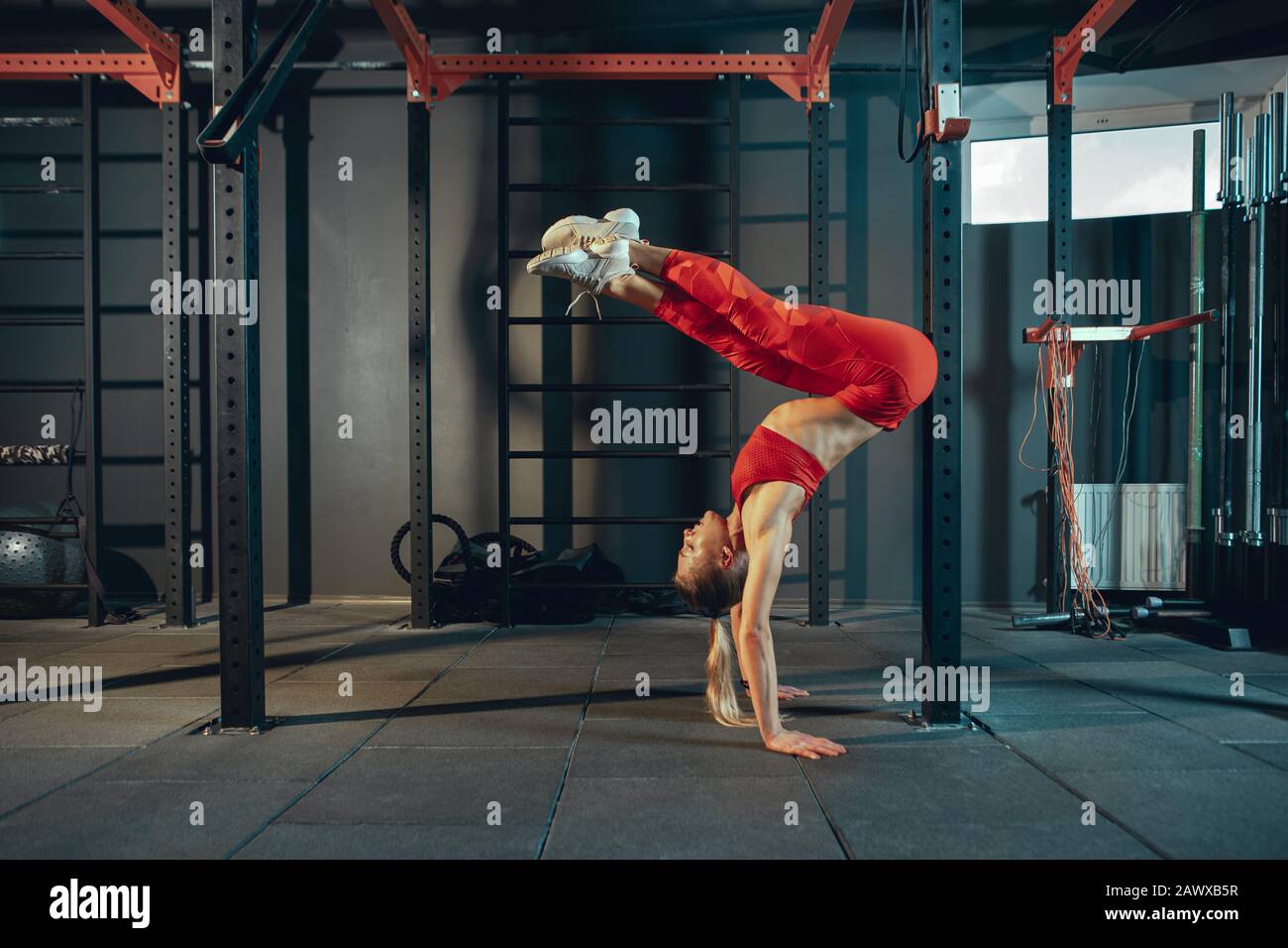 Balanced. Young muscular caucasian woman practicing in gym. Athletic ...
