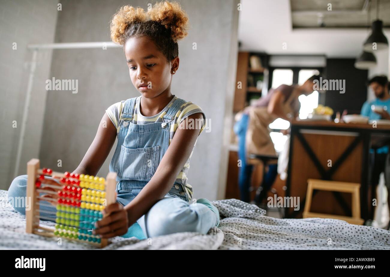 Happy african american kid girl learn to count at home with abacus ...