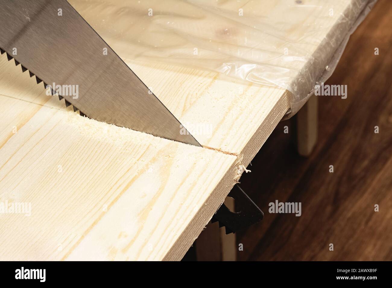 Sawing a wood board with a saw Stock Photo - Alamy