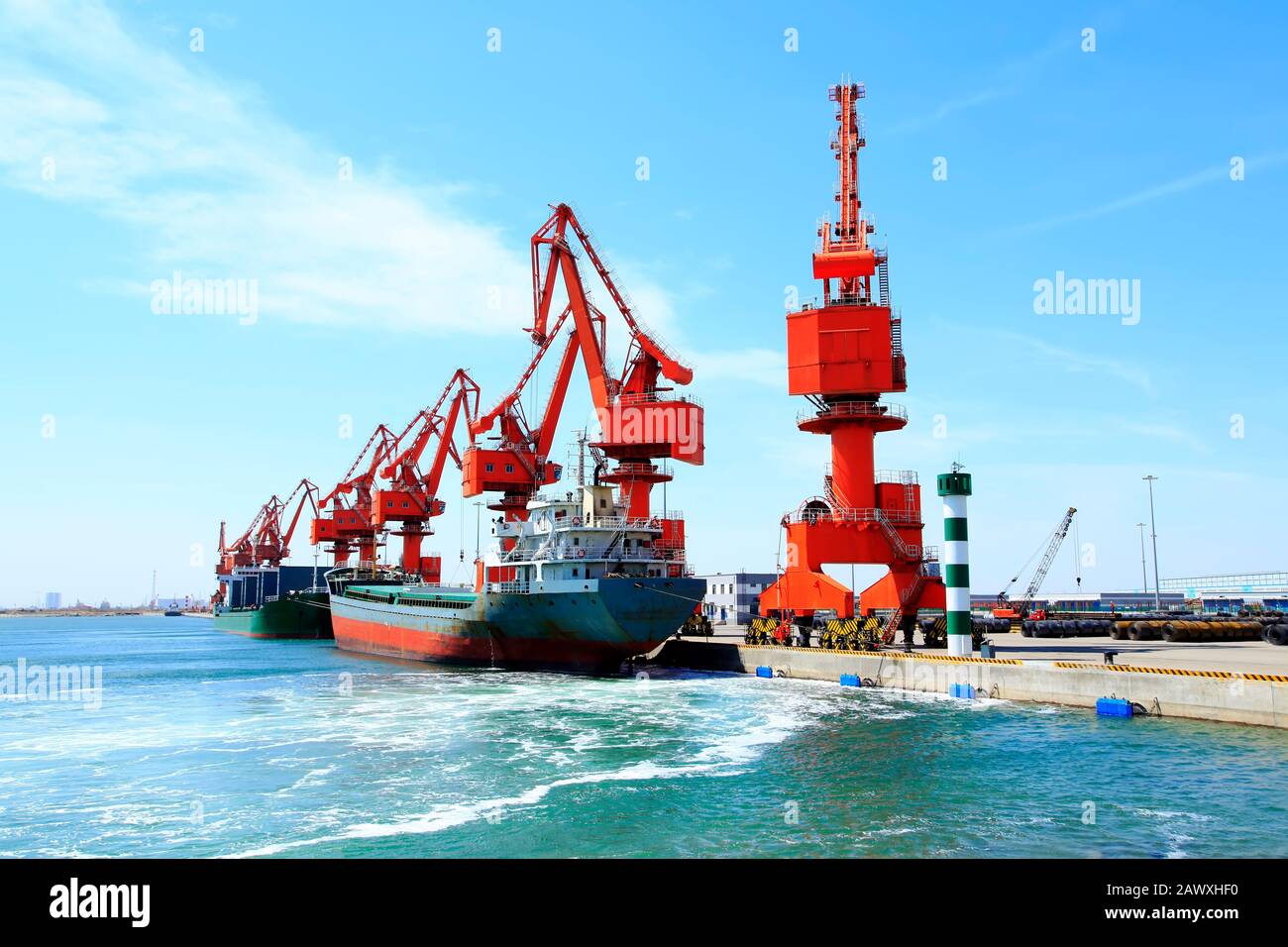 In freight terminal, gantry crane and cargo ships are in loading and ...