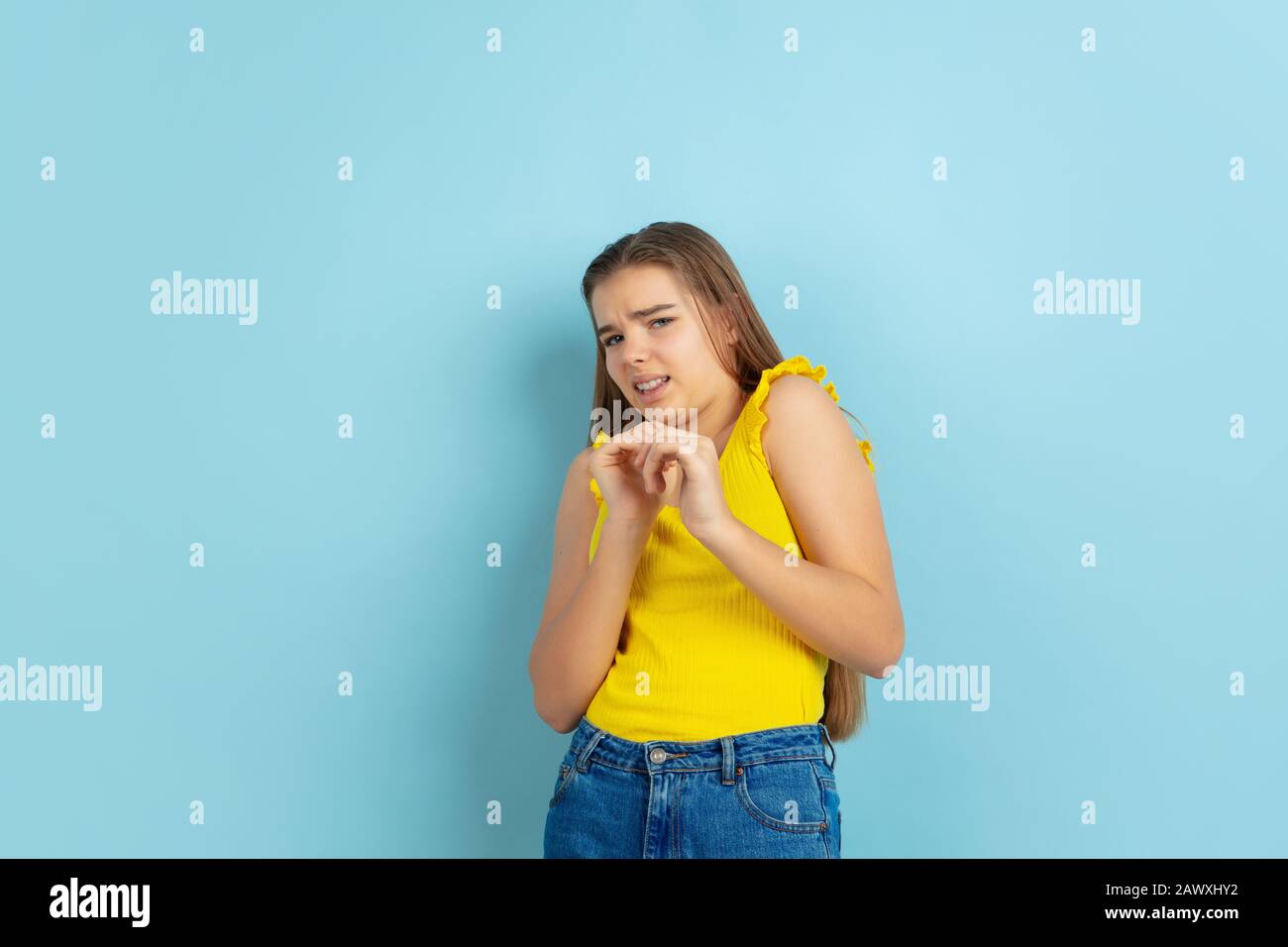 Shocked, scared. Caucasian teen girl's portrait isolated on blue ...