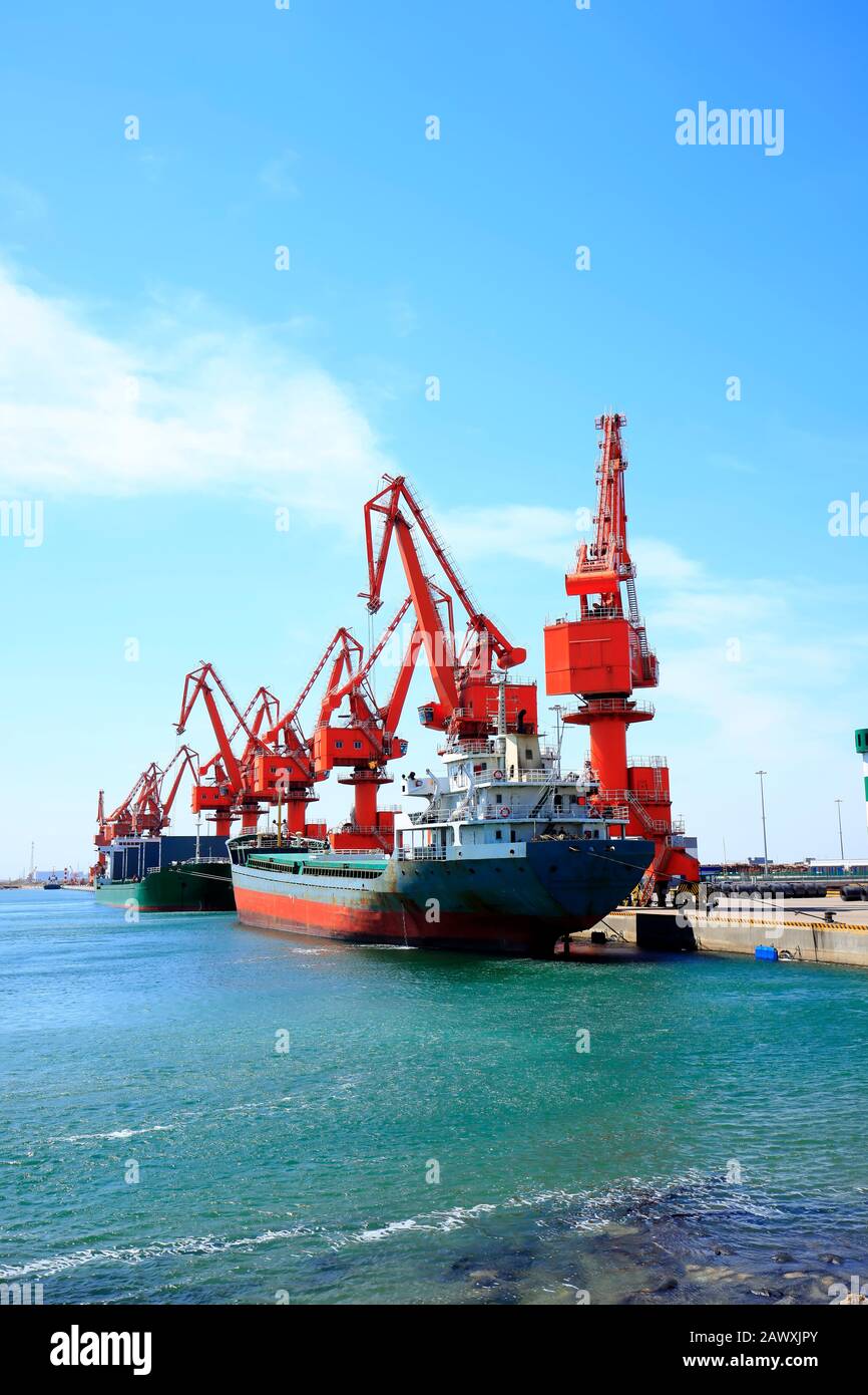 In freight terminal, gantry crane and cargo ships are in loading and ...