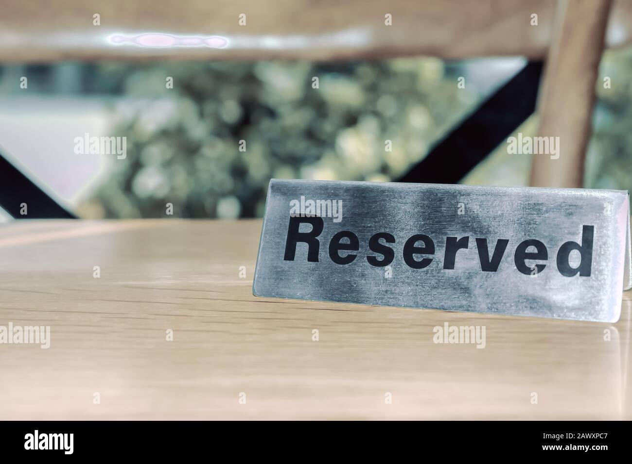 Stainless Steel Reserved Table Sign on the wooden table of restaurant ...