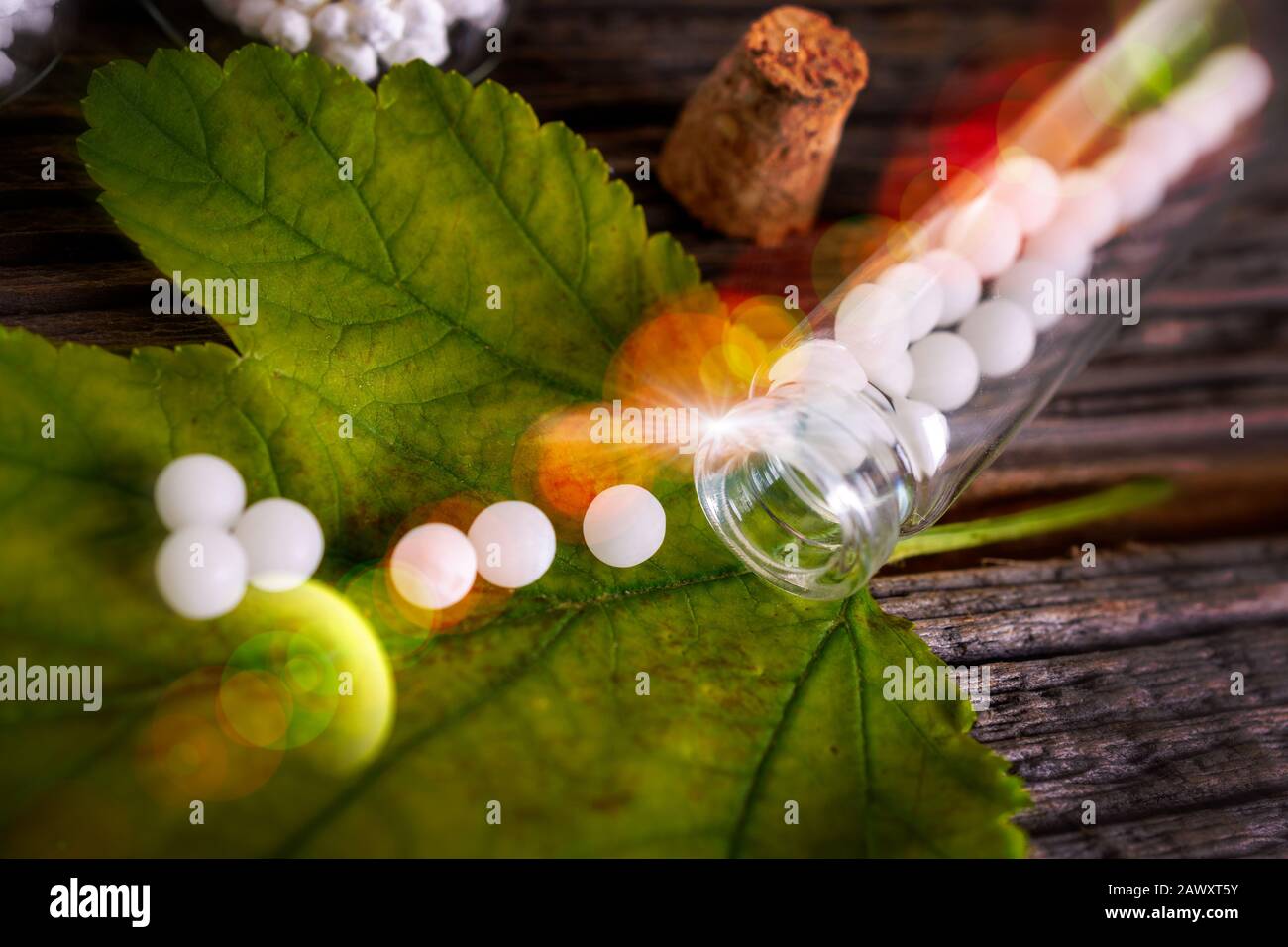 Homeopathic lactose sugar globules on leaf with glass bottle Stock ...