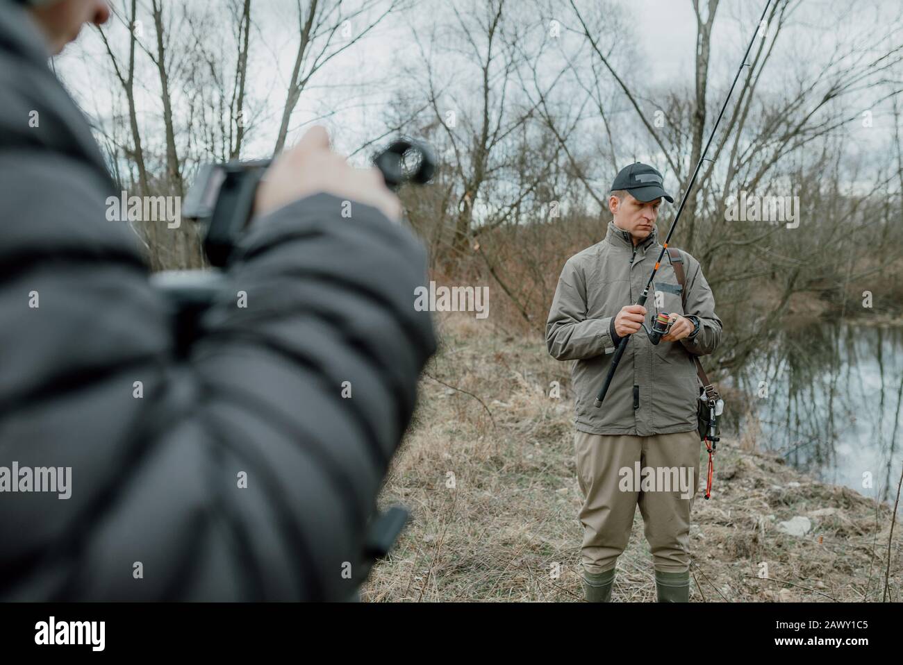 Camera operator looks at the preview monitor while presenter recording ...