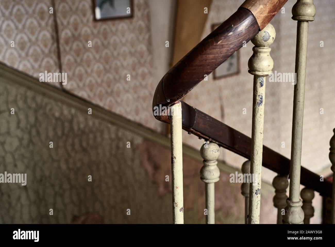 Close-up wooden railing with iron balusters on a staircase of an old ...