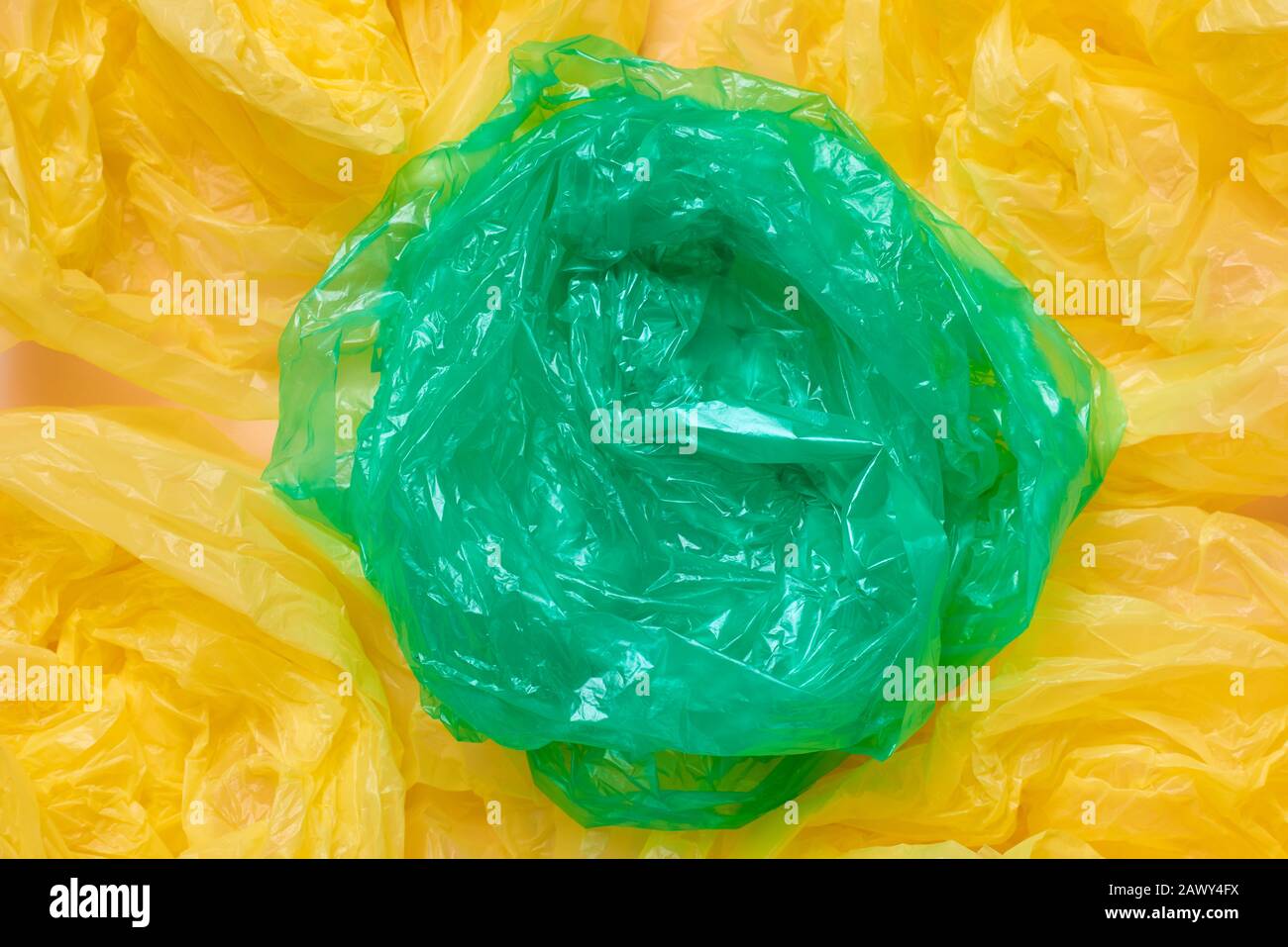 Horizontal from above flat lay shot of one empty green plastic garbage ...