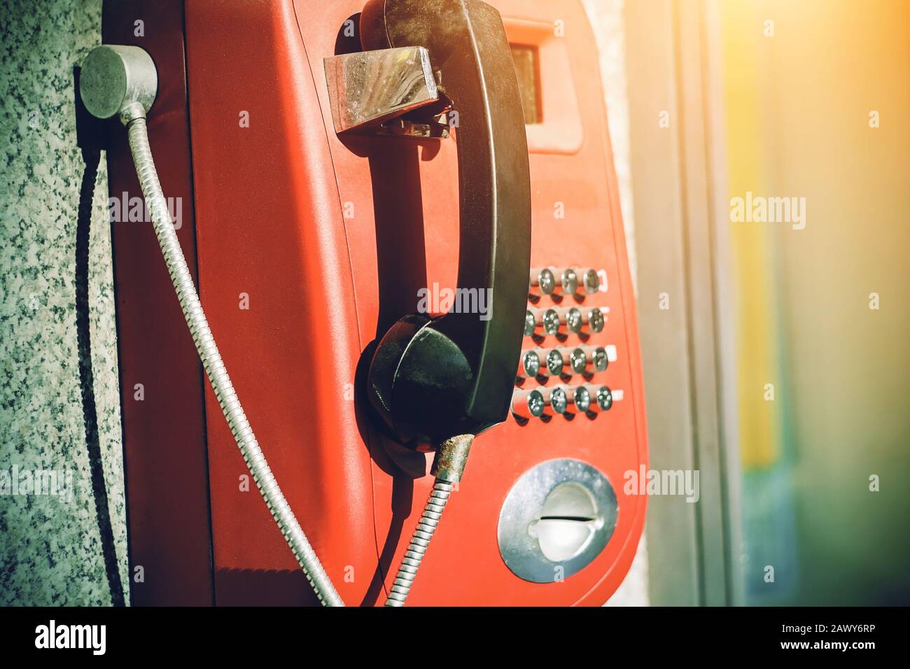 Street retro red vending machine with phone, illuminated by bright ...