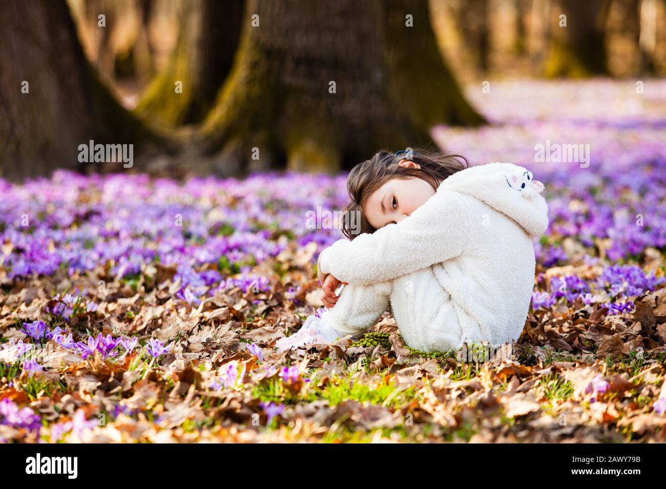 Lonely girl sitting on a ground in spring forest Stock Photo - Alamy