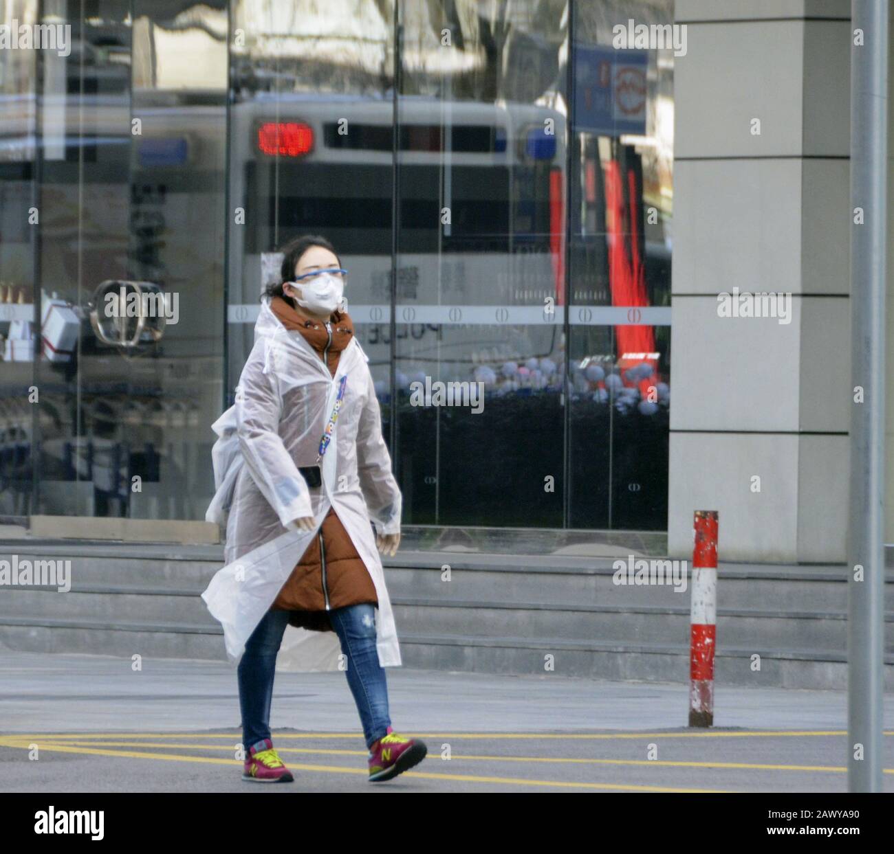 Beijing, China. 10th Feb 2020. A woman wears a mask and raincoat in ...