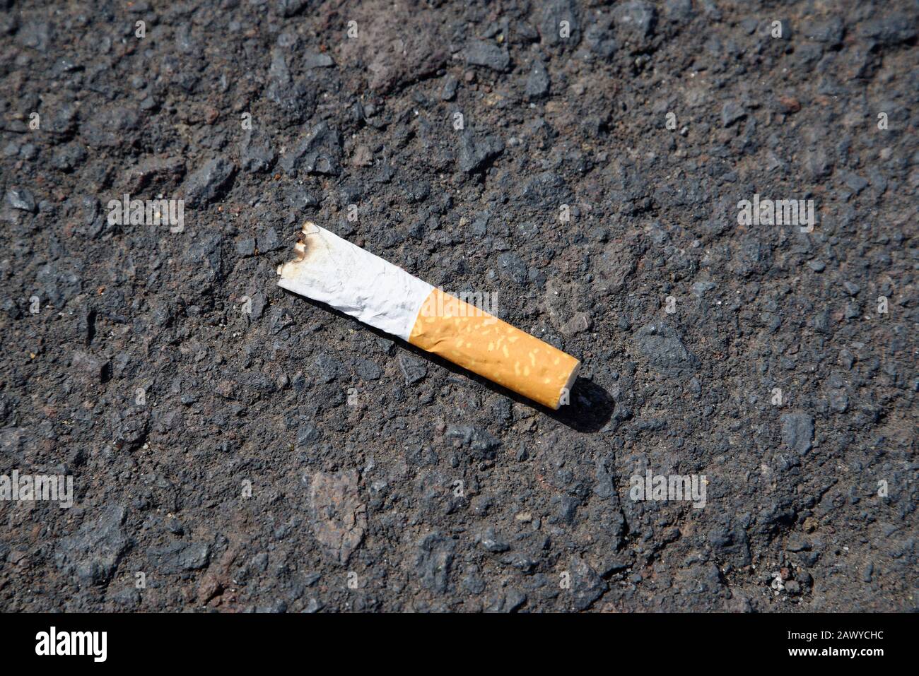 Cigarette butt dropped on the ground Stock Photo - Alamy