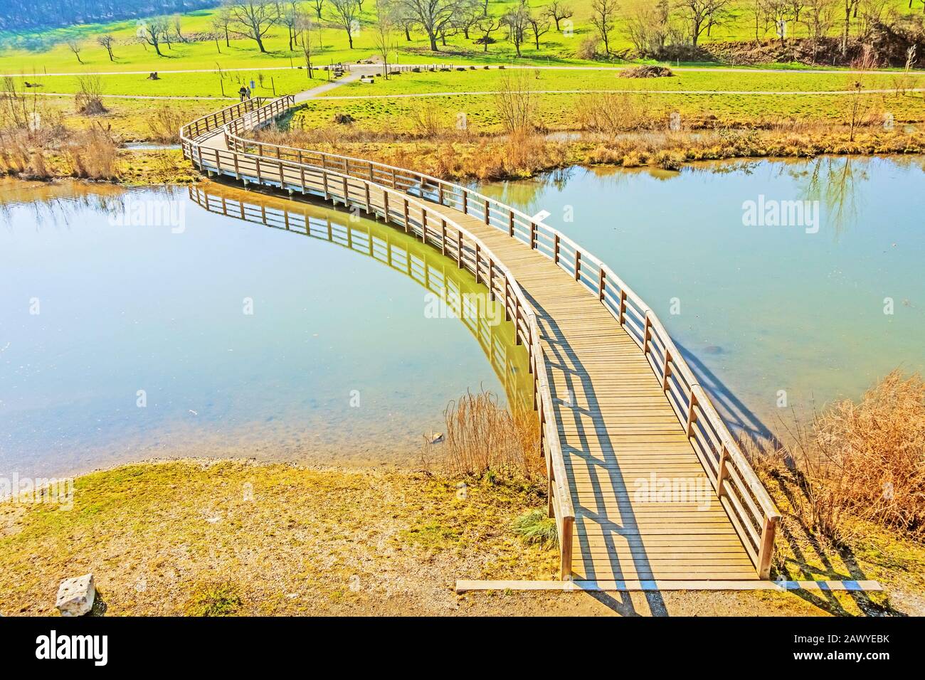 Pier / path over river through rural landscape Stock Photo - Alamy