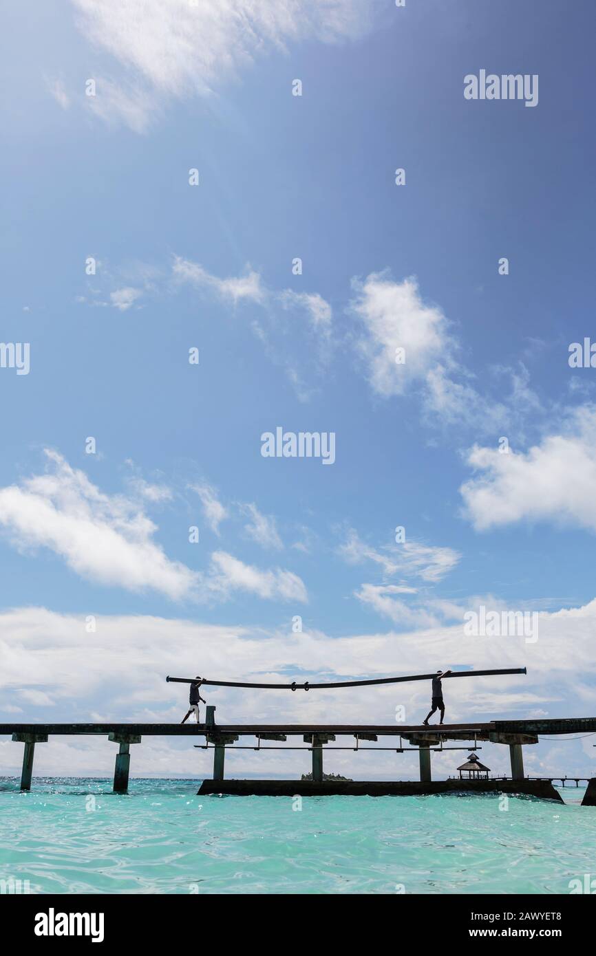 Men on sunny dock over ocean under blue sky, Maldives Stock Photo - Alamy
