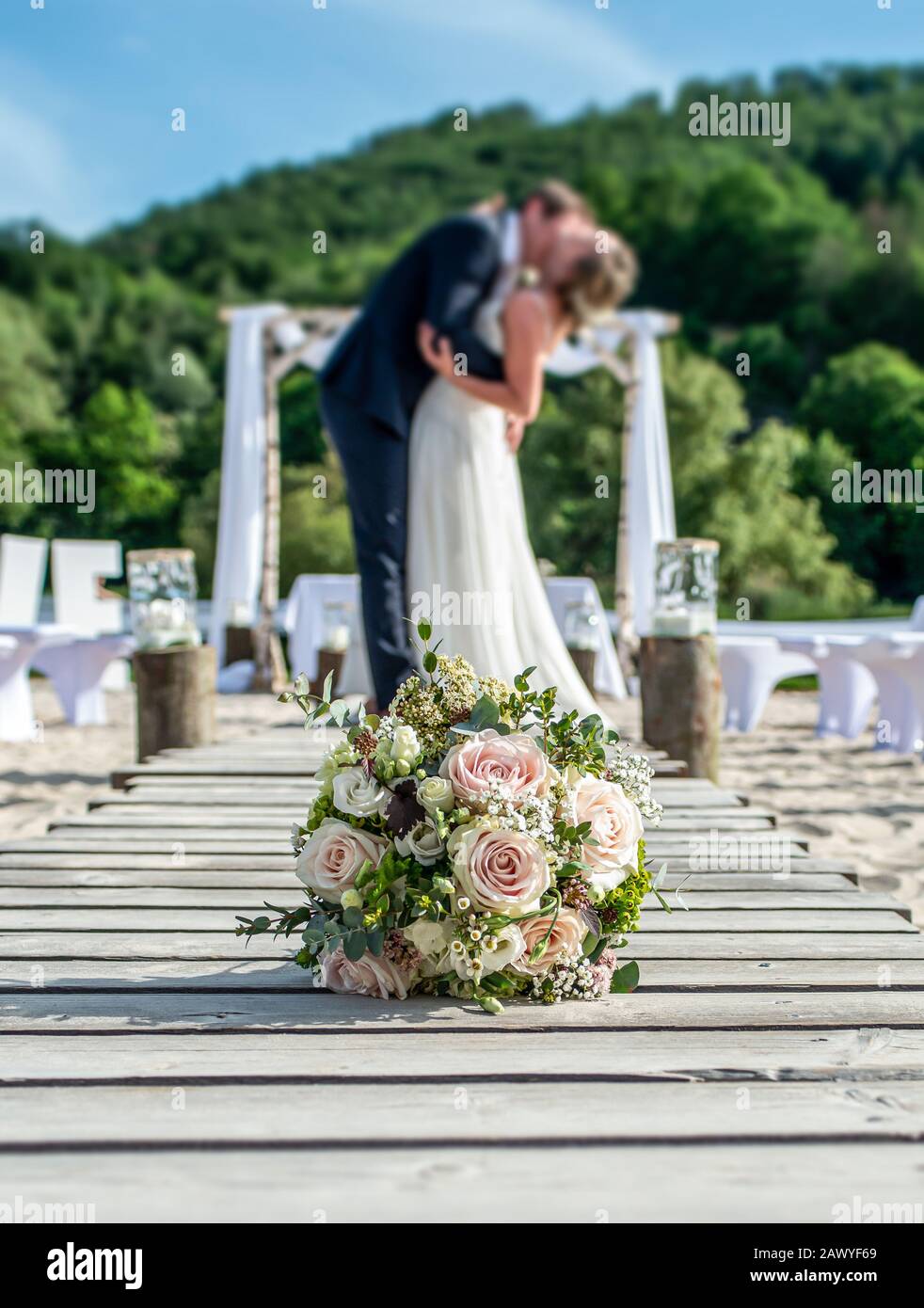 Wedding bouquet in front of newlyweds wedding couple inbackground ...