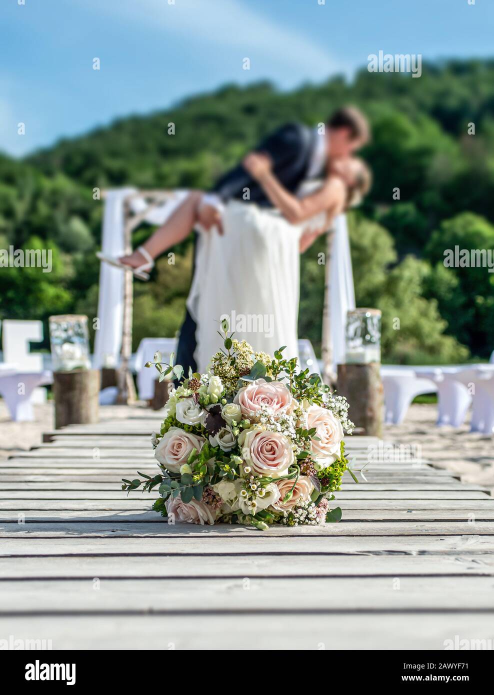 Wedding bouquet in front of newlyweds wedding couple inbackground ...