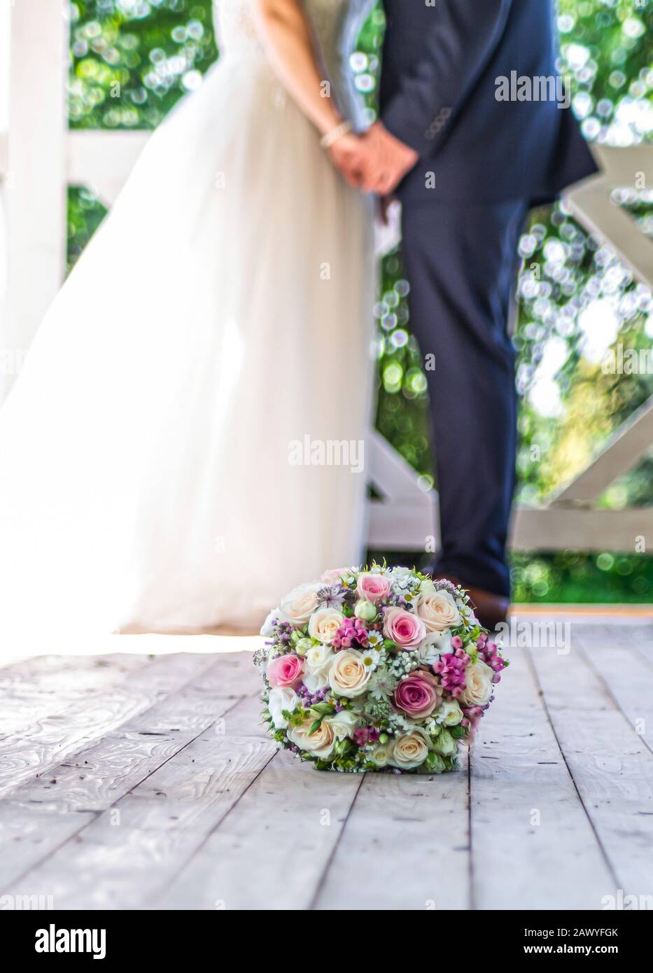 Wedding bouquet in front of newlyweds wedding couple inbackground ...