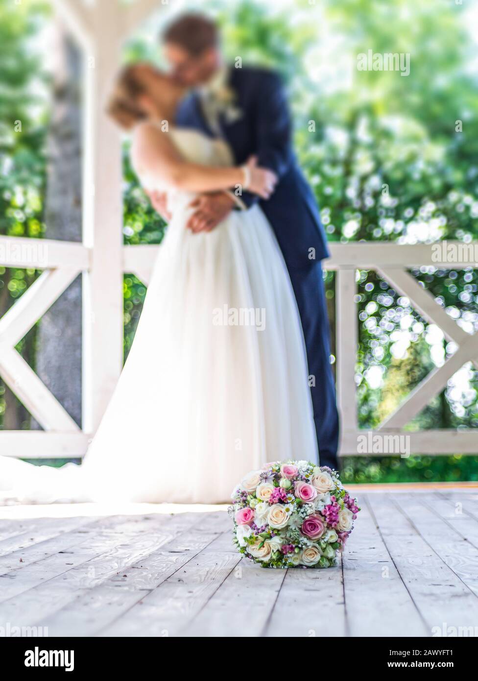Wedding bouquet in front of newlyweds wedding couple inbackground ...