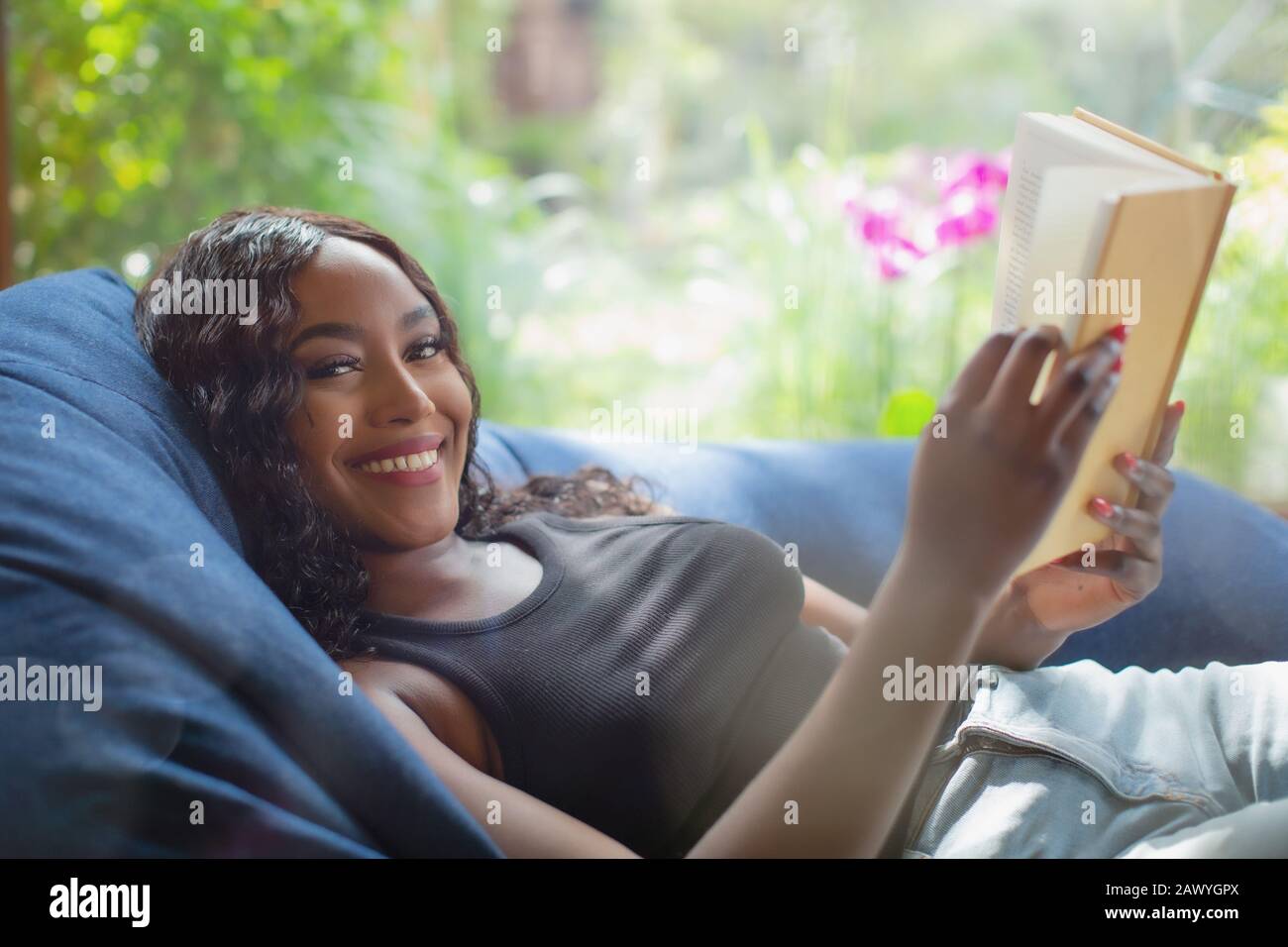 Woman reading book looking camera hi-res stock photography and images ...