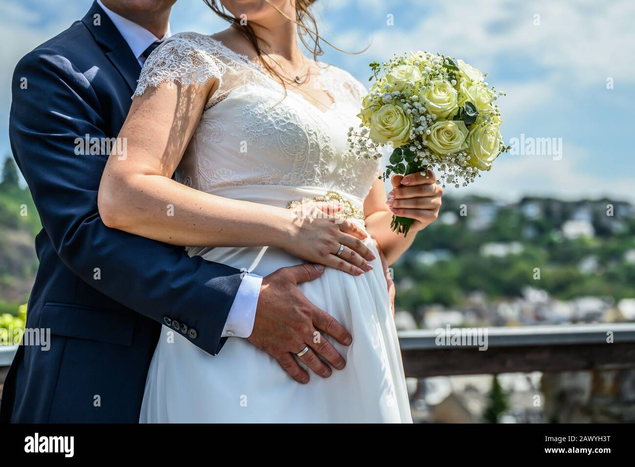 hands groom and bride with wedding rings and wedding bouquet flowers on ...