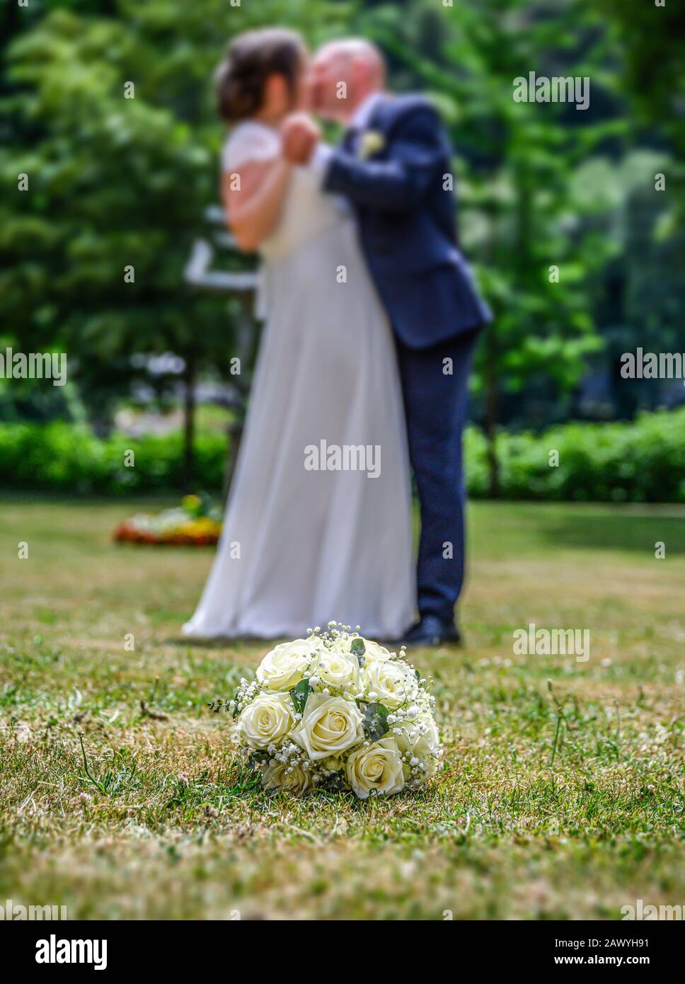 Wedding bouquet in front of newlyweds wedding couple inbackground ...