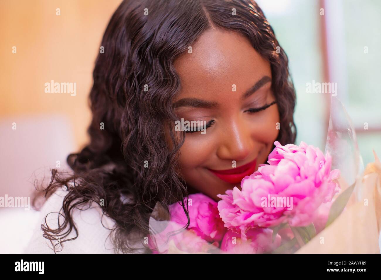 Close up serene young woman smelling fresh pink peony flowers Stock ...