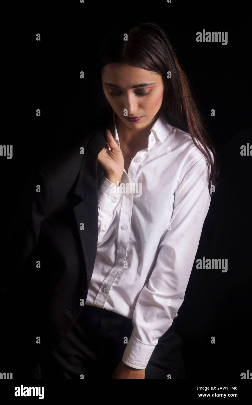 Studio shot of fashion model in black business suit. Looking down Stock ...