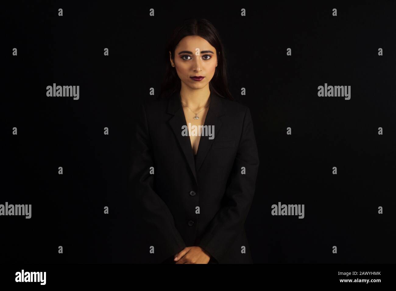 Studio shot of fashion model in black business suit. Looking at camera ...