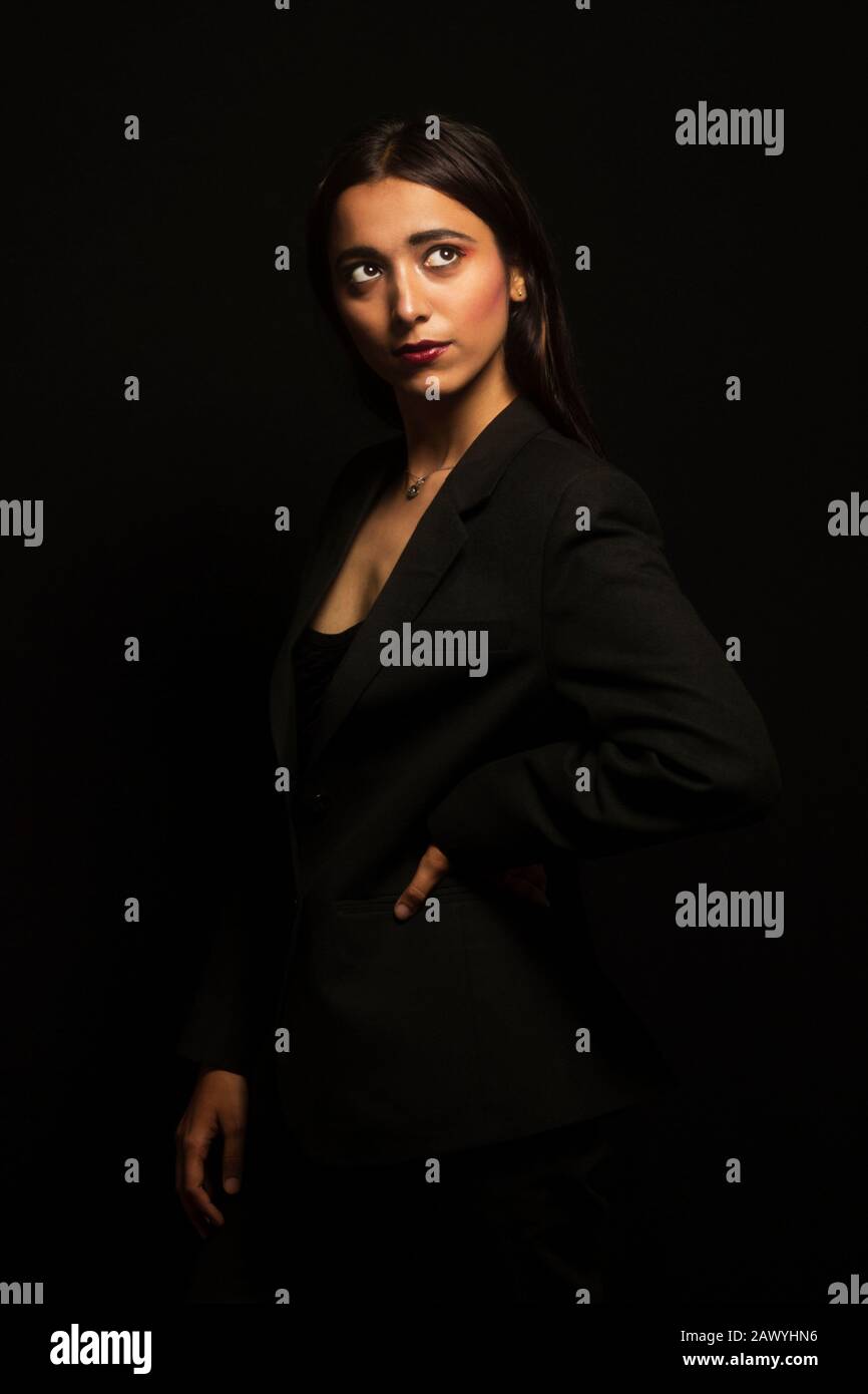 Studio shot of fashion model in black business suit, looking sideways ...