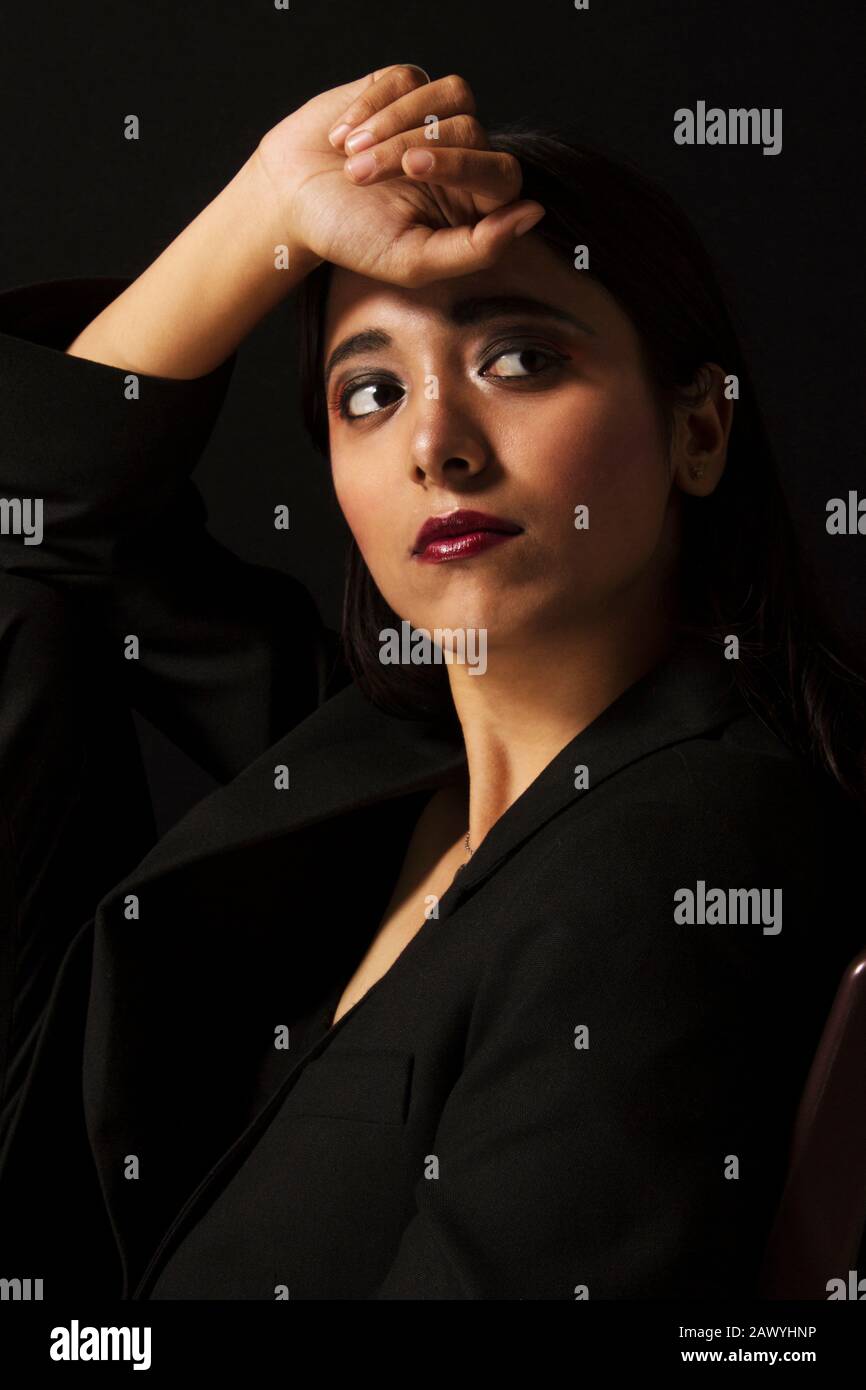 Studio shot of fashion model in black business suit, looking sideways ...