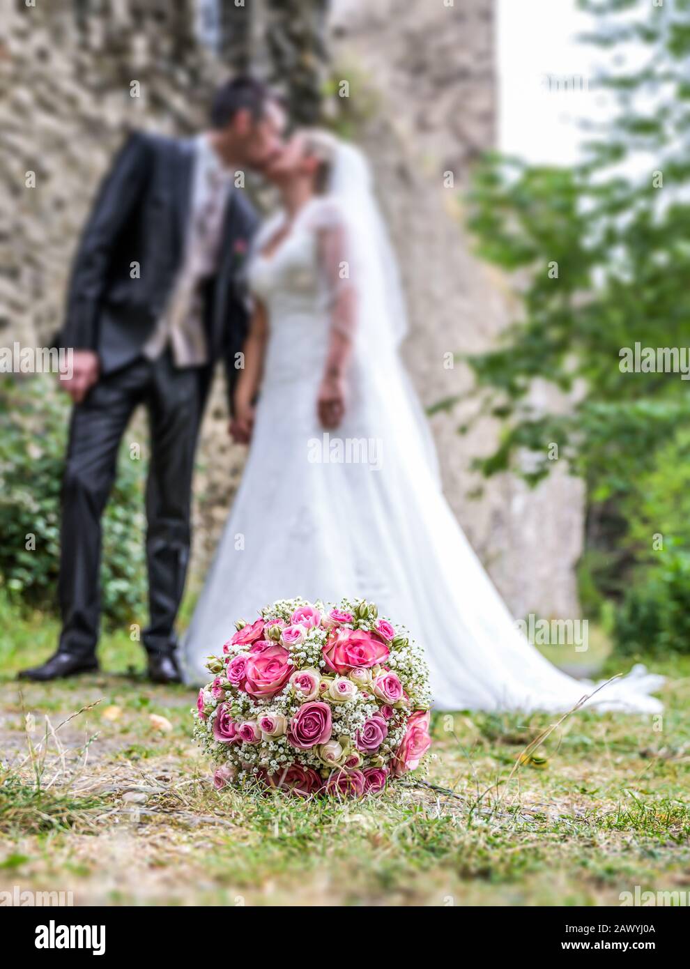 Wedding bouquet in front of newlyweds wedding couple inbackground ...