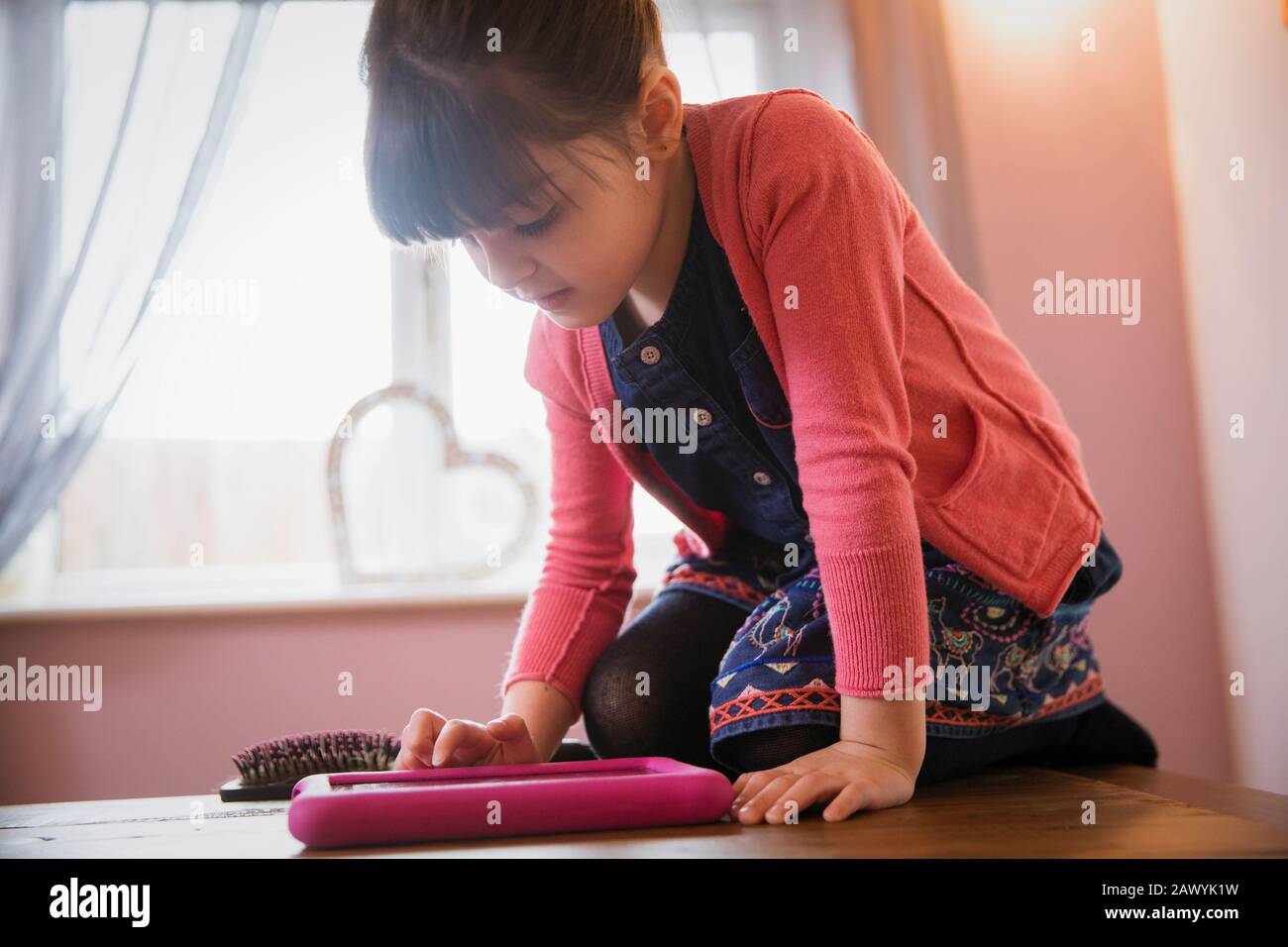 Curious girl using digital tablet Stock Photo - Alamy