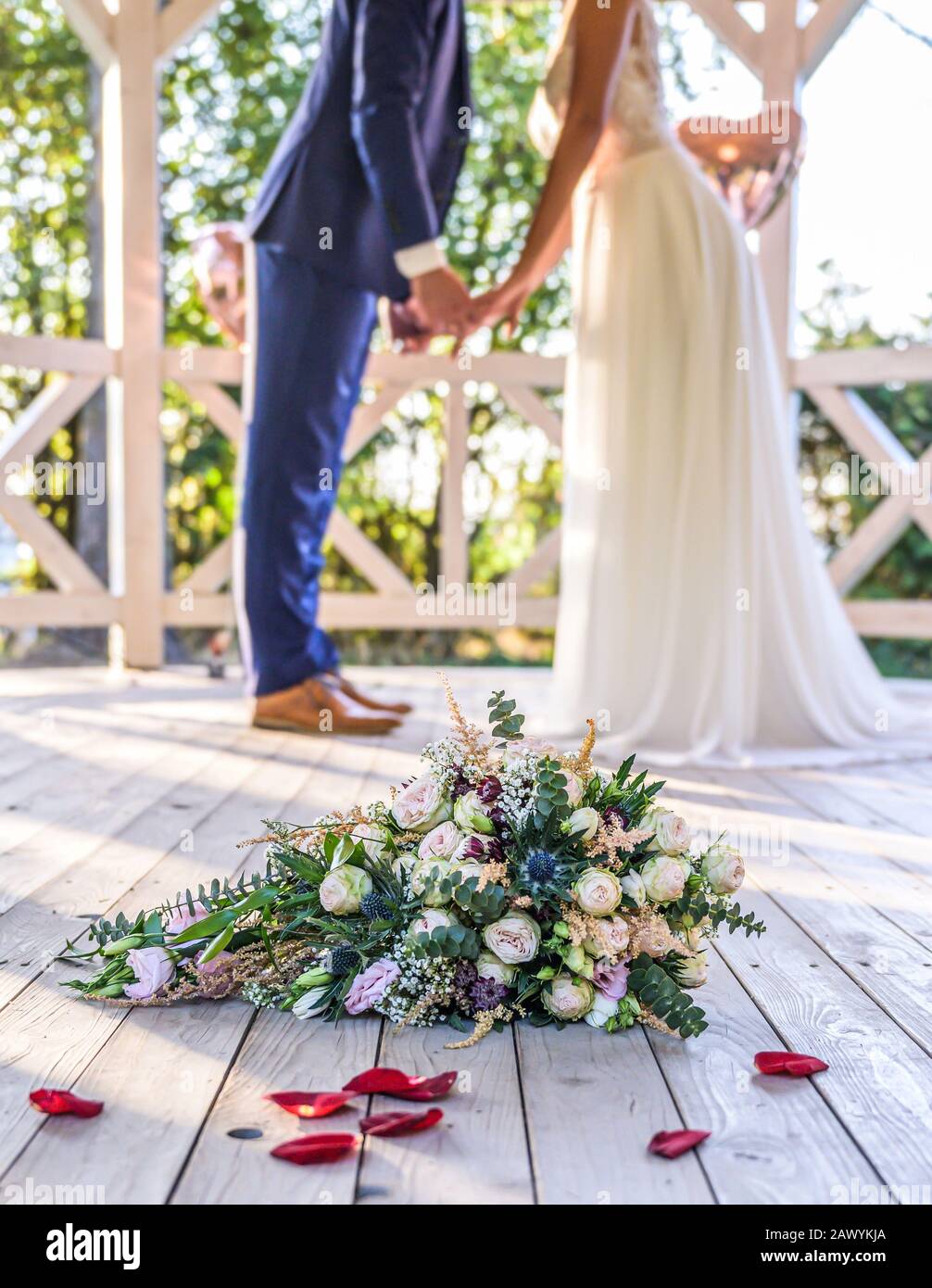 Wedding bouquet in front of newlyweds wedding couple inbackground ...