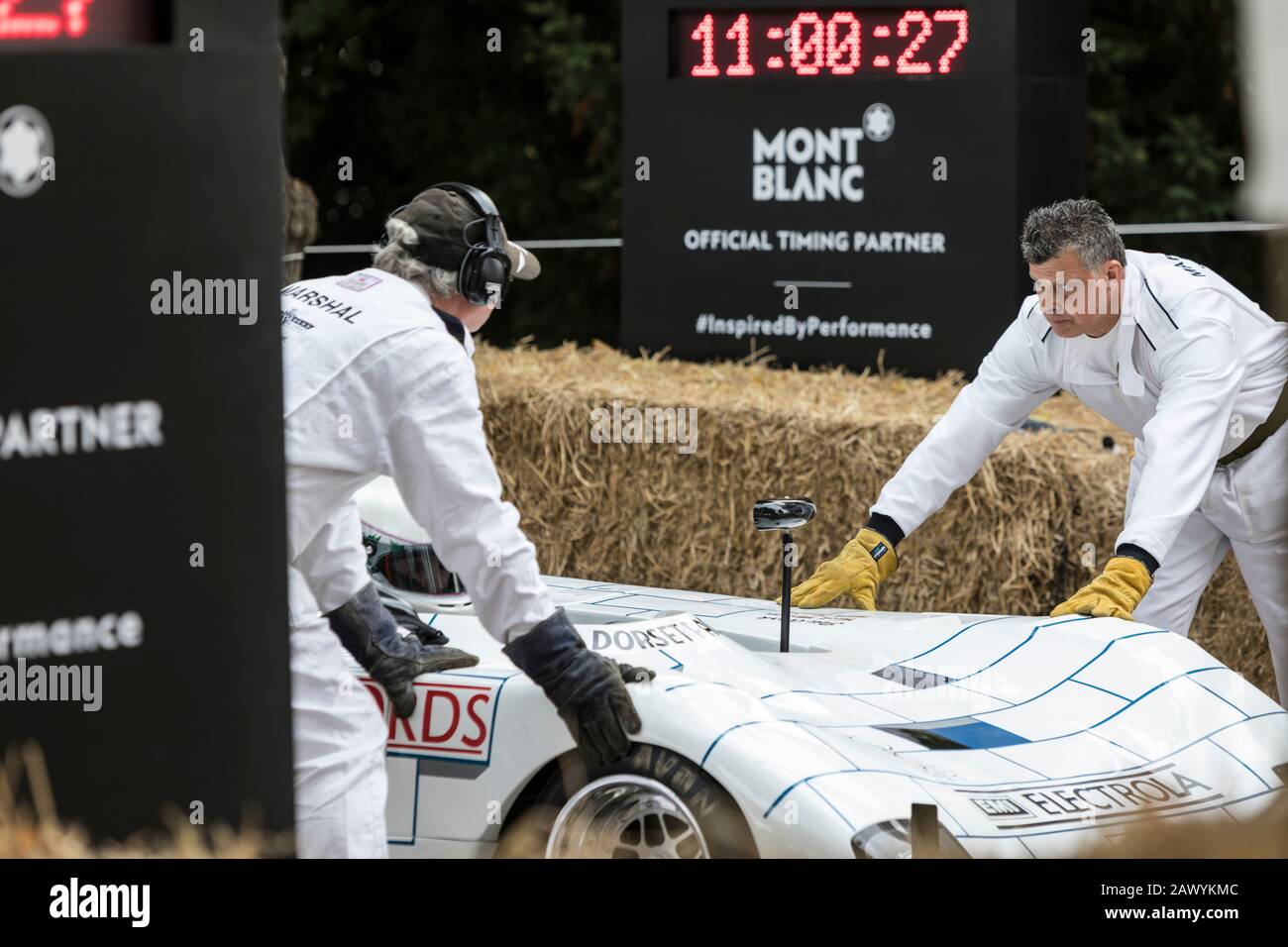 Race marshals hold a racing car on the start line in the 2018 Goodwood ...