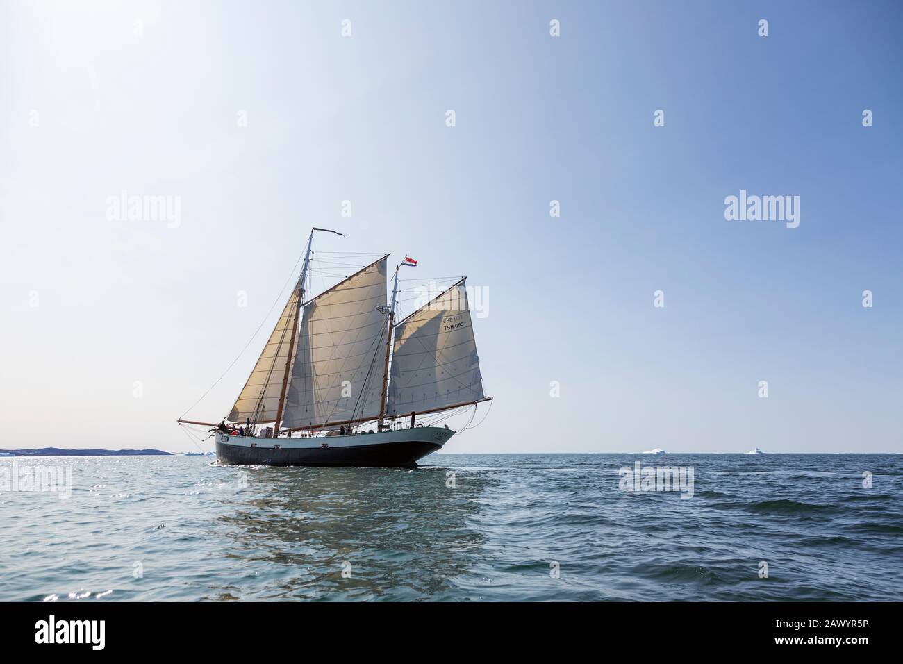 Ship with Netherlands flag sailing on sunny Atlantic Ocean Greenland ...