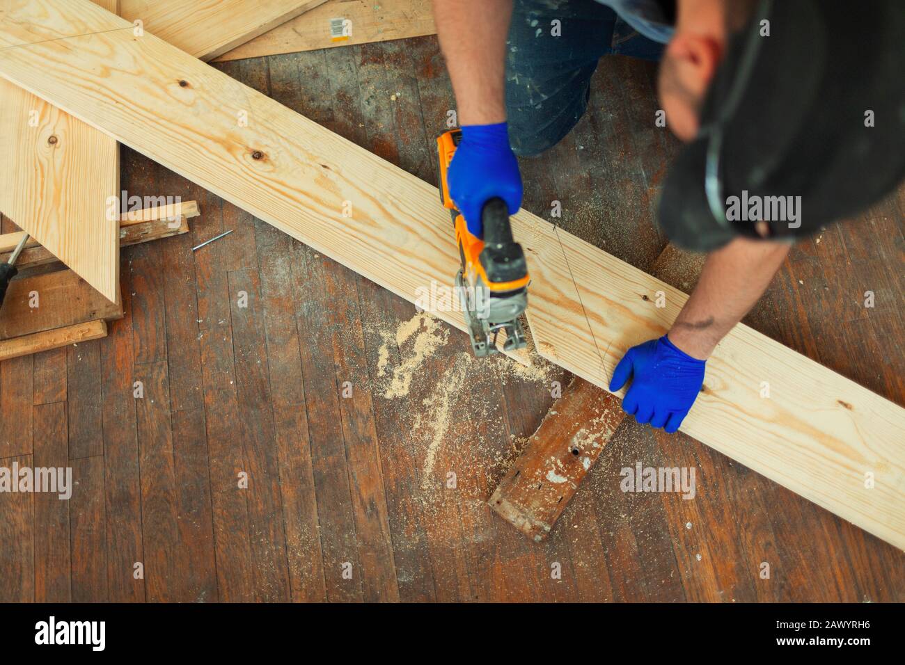 Carpenter cutting wood with saw at construction site Stock Photo - Alamy