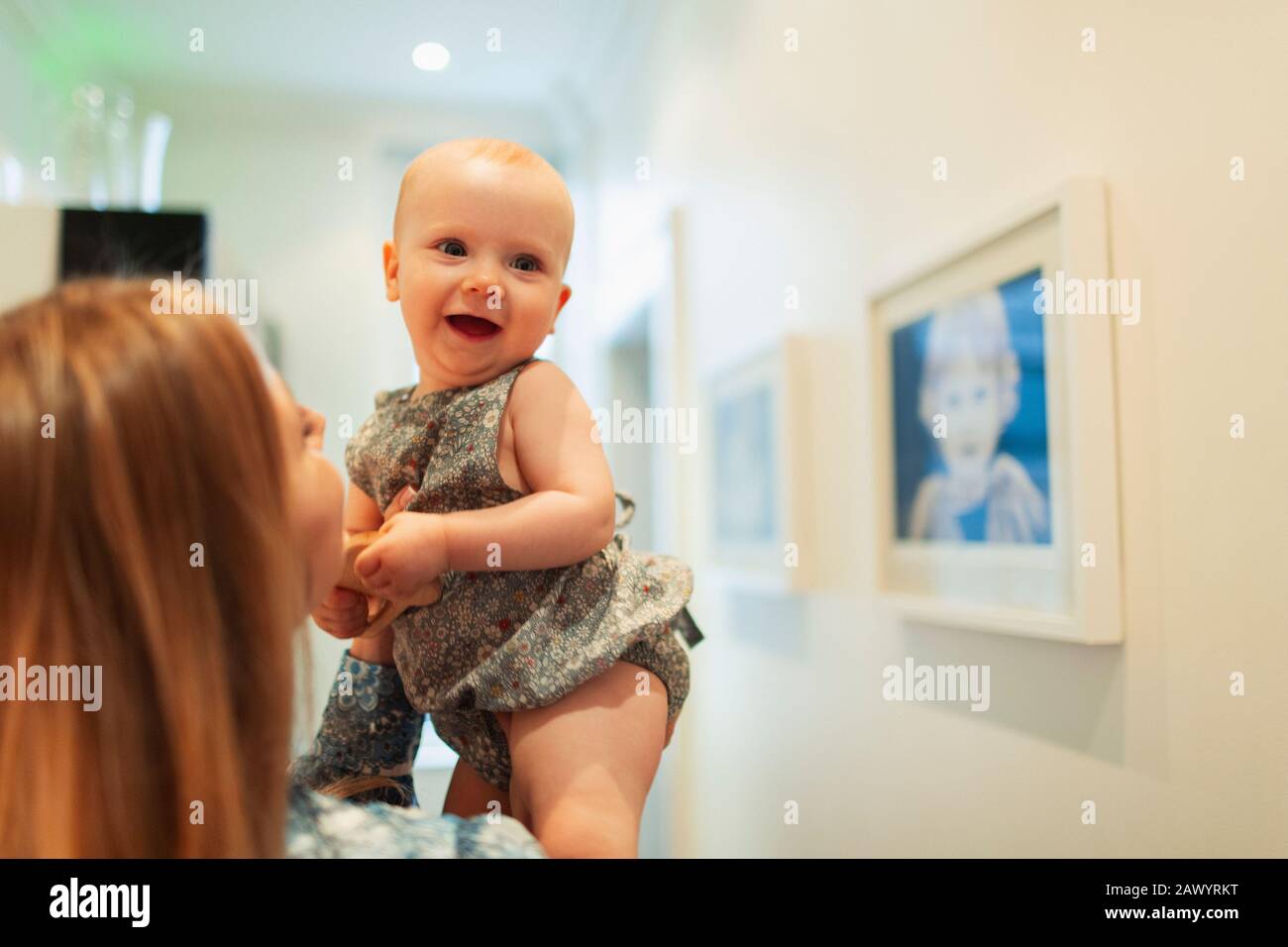 Mother holding happy cute baby girl in corridor Stock Photo - Alamy